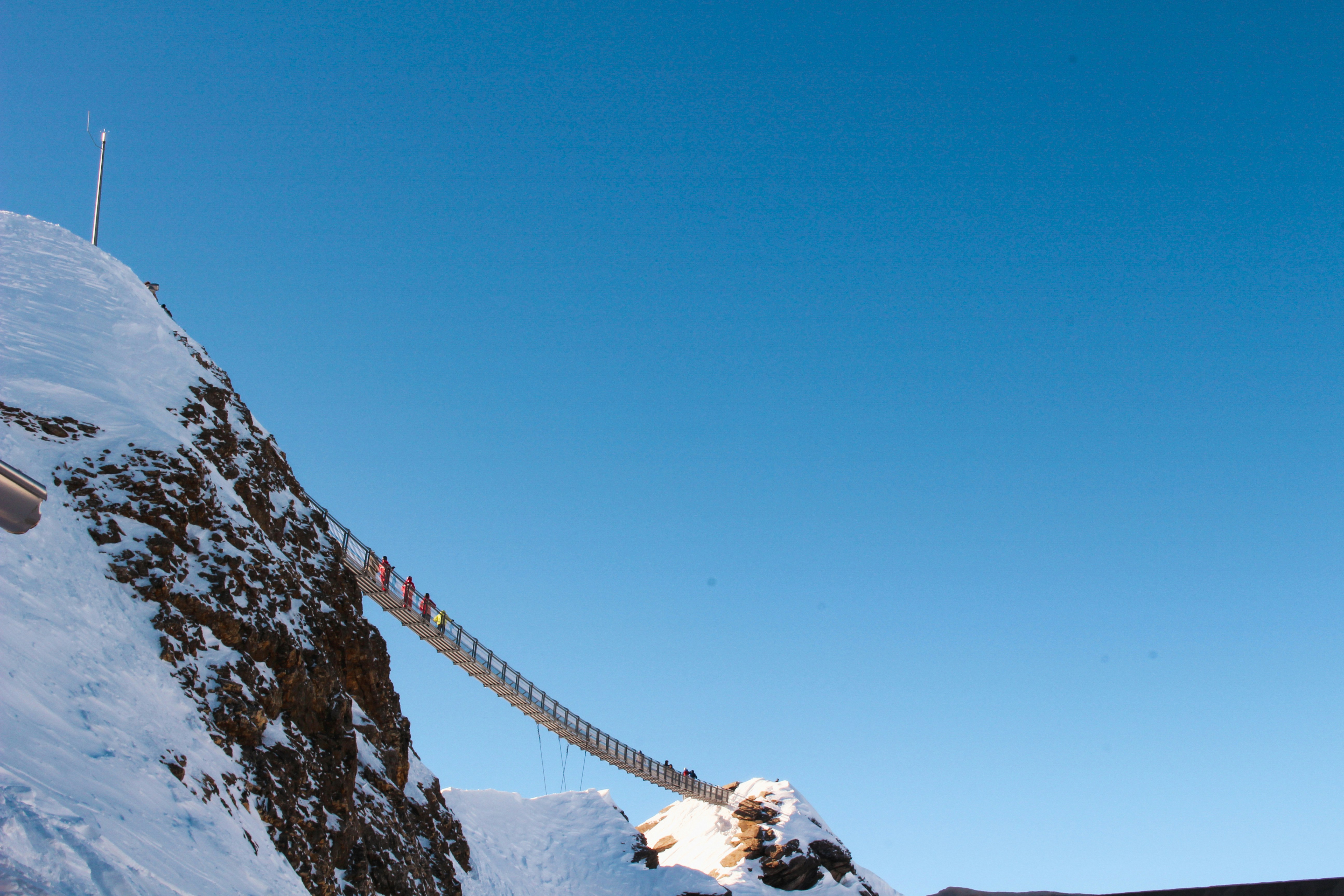 Suspended Snow Bridge Beneath a Clear Alpine Sky