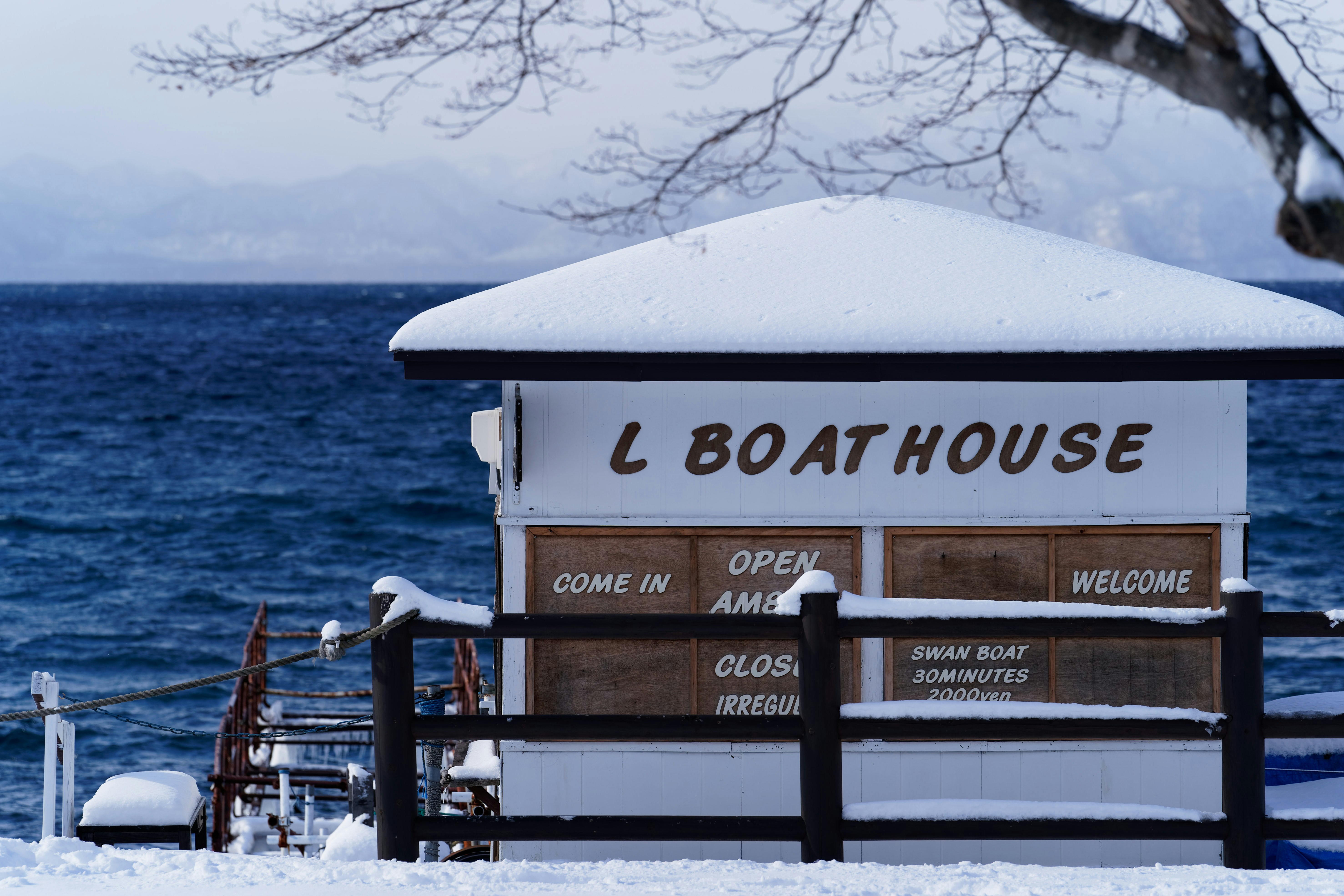 Snow-Capped Boathouse by a Tranquil Snow Sea