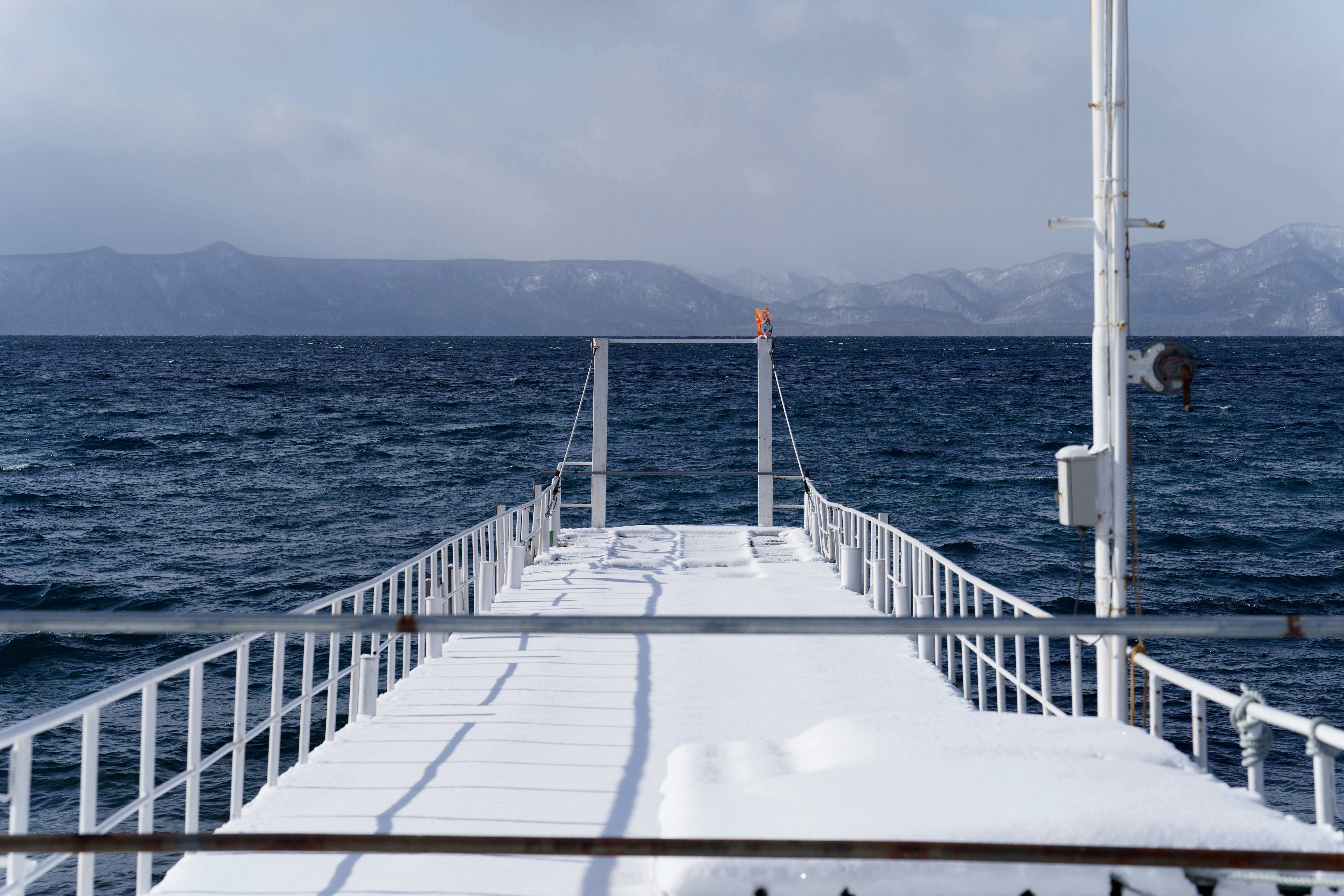 A Snow-Capped Pier Reaching Toward a Distant Sea