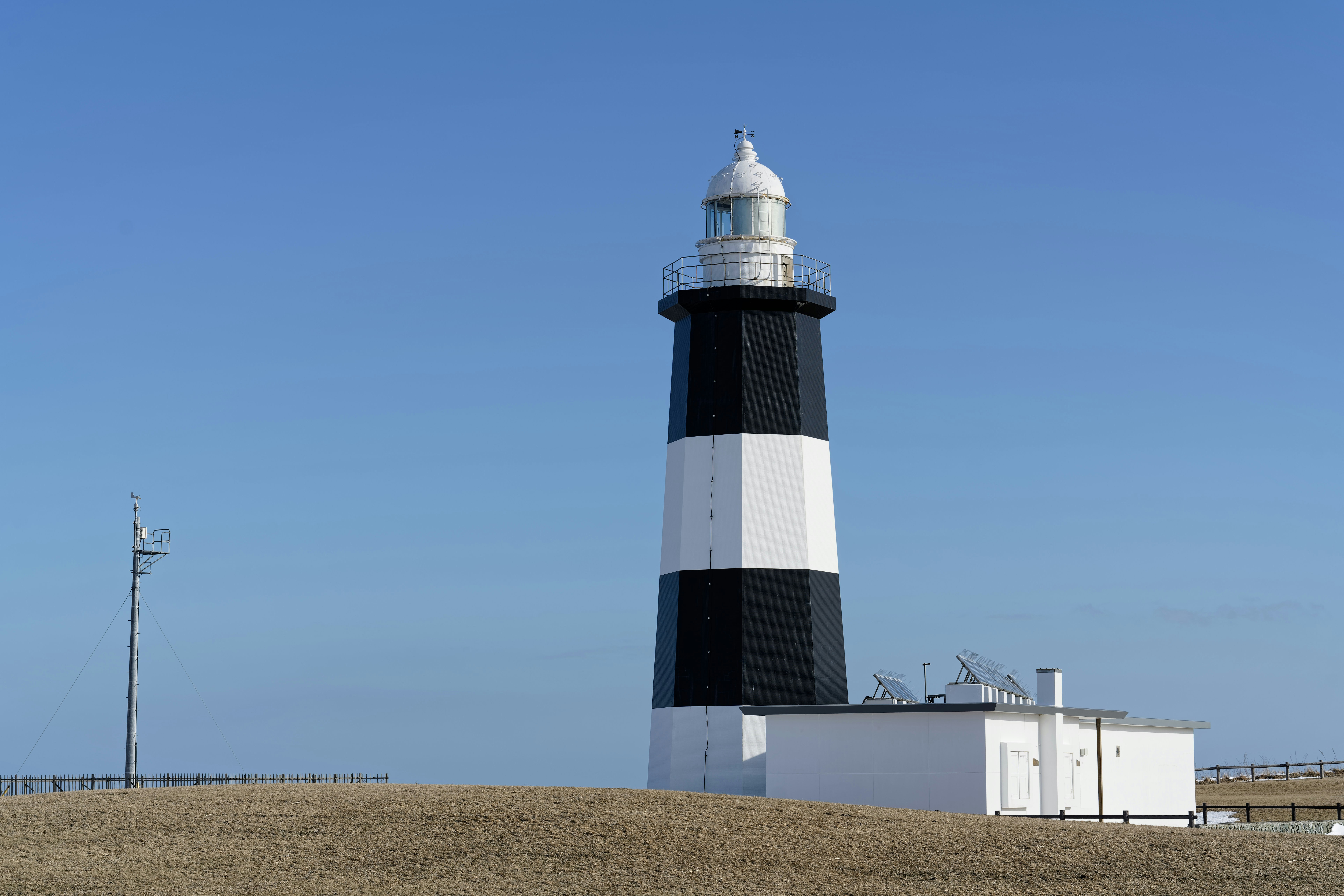 Harbor Beacon: A Lone Lighthouse Standing Against the Blue