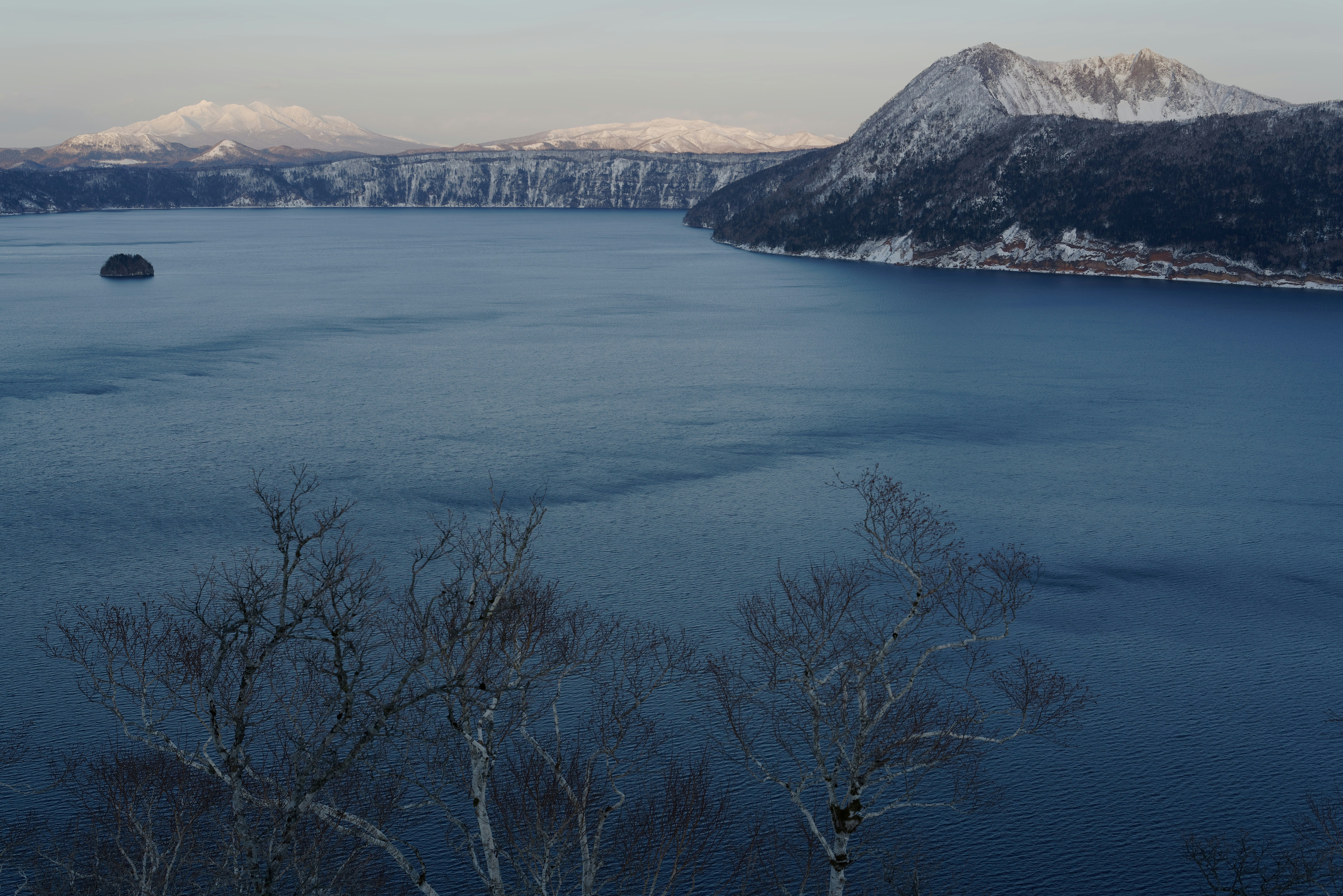 Glacial Lake Vista at Dusk: Snow-Capped Peaks Over a Quiet Fjord