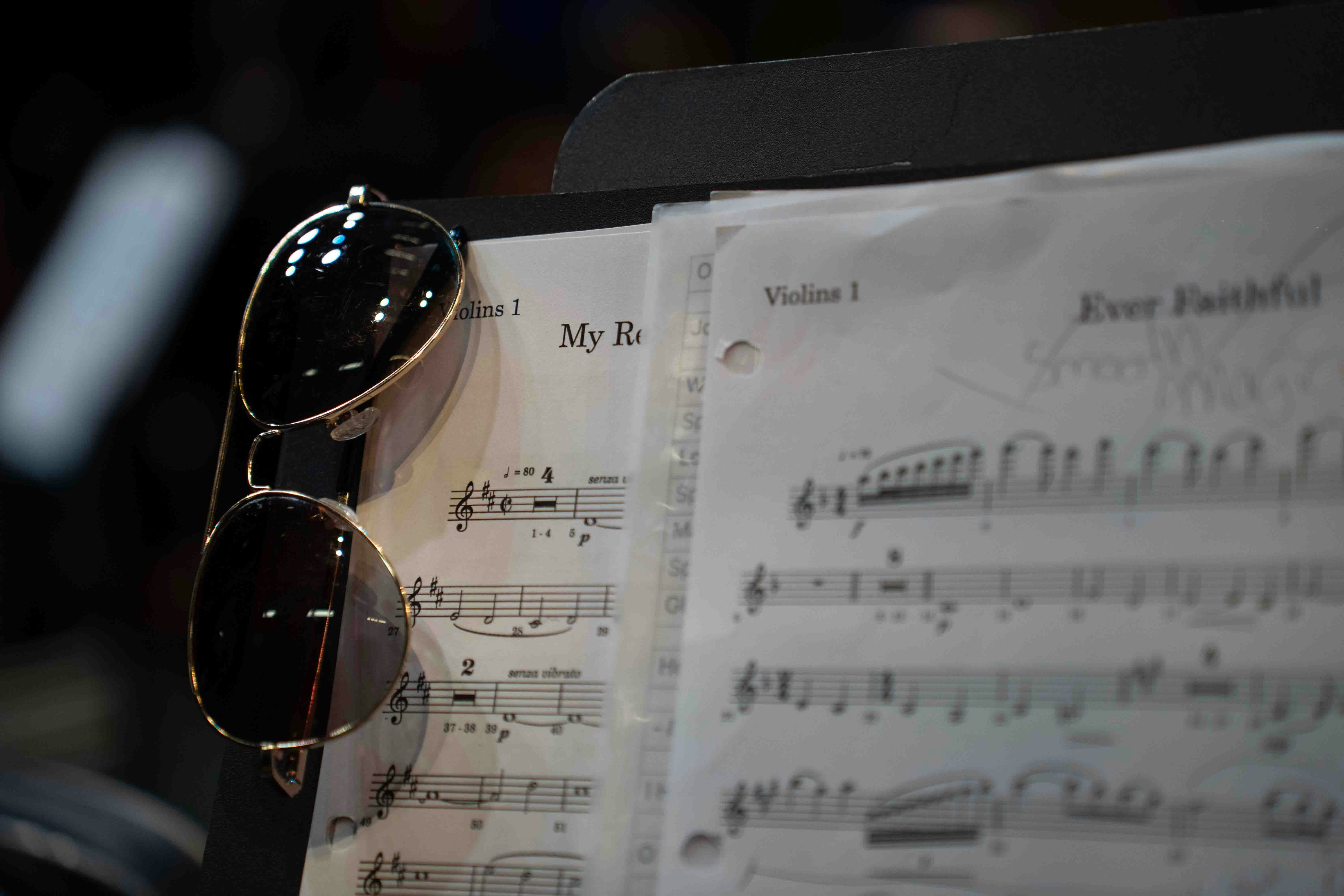Sunglasses Rest on Sheet Music: A Quiet Rehearsal Moment