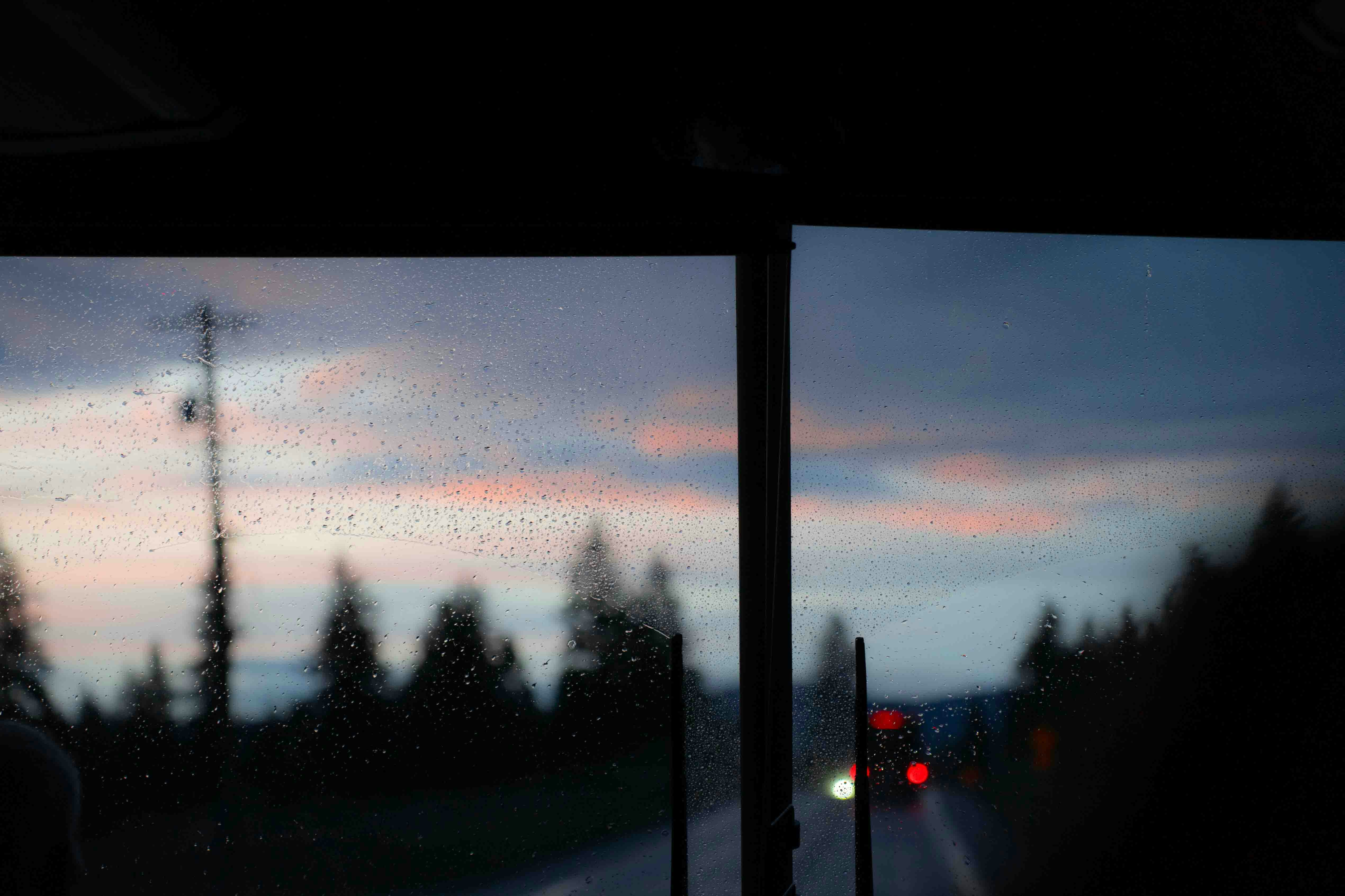 Distant Tail Lights Through Rain-Streaked Windows at Dusk