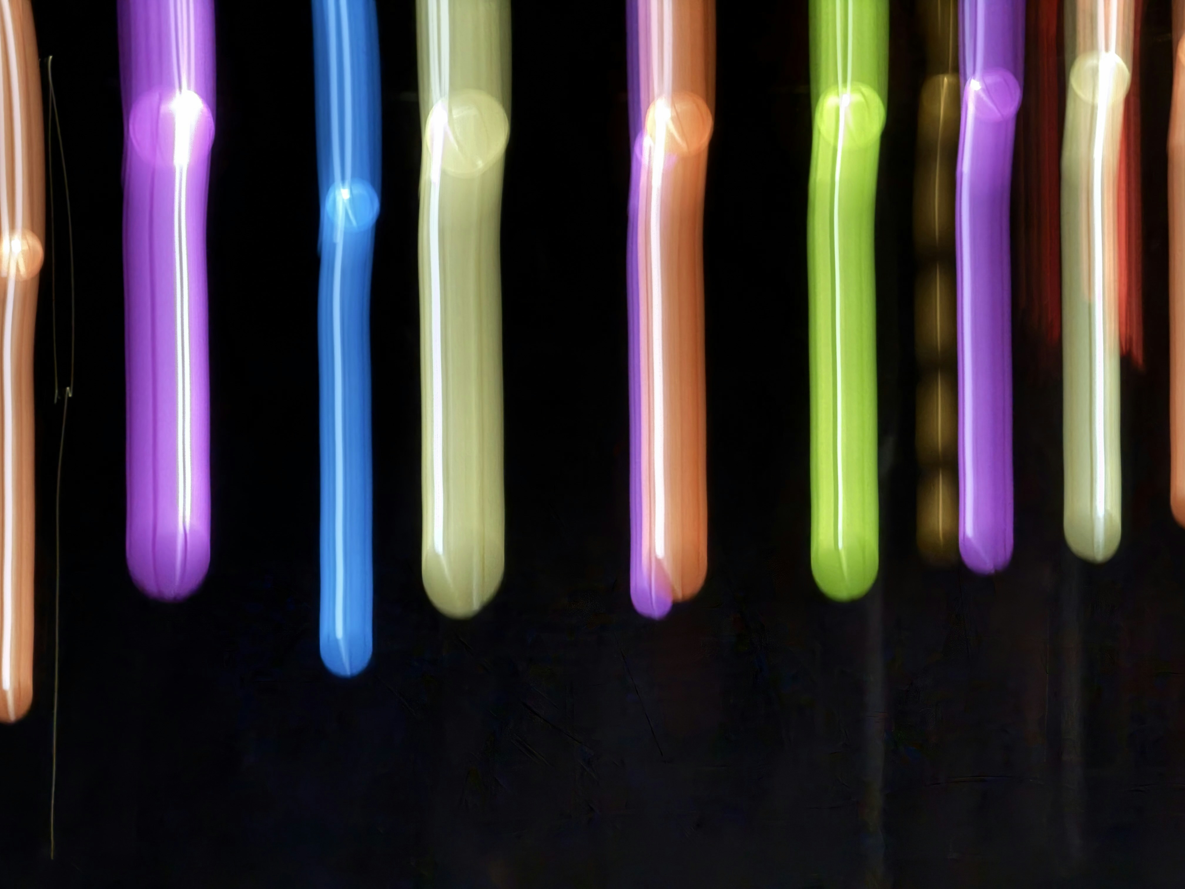 Neon Threads: A Row of Floating Glass Rods in Night