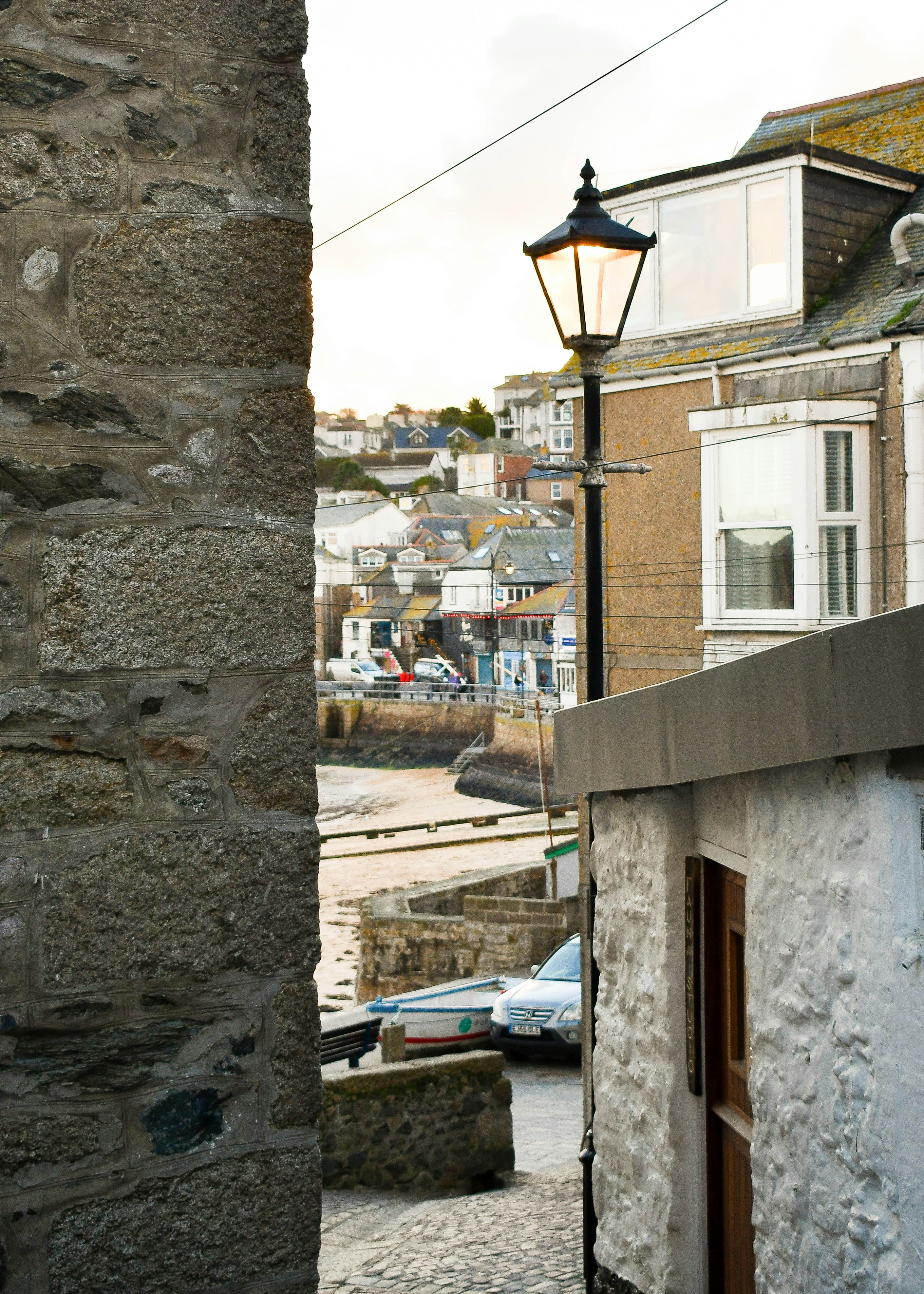 Lantern-lit Lane: A Quiet Coastal Street Framed by Stone and Whitewashed Facades