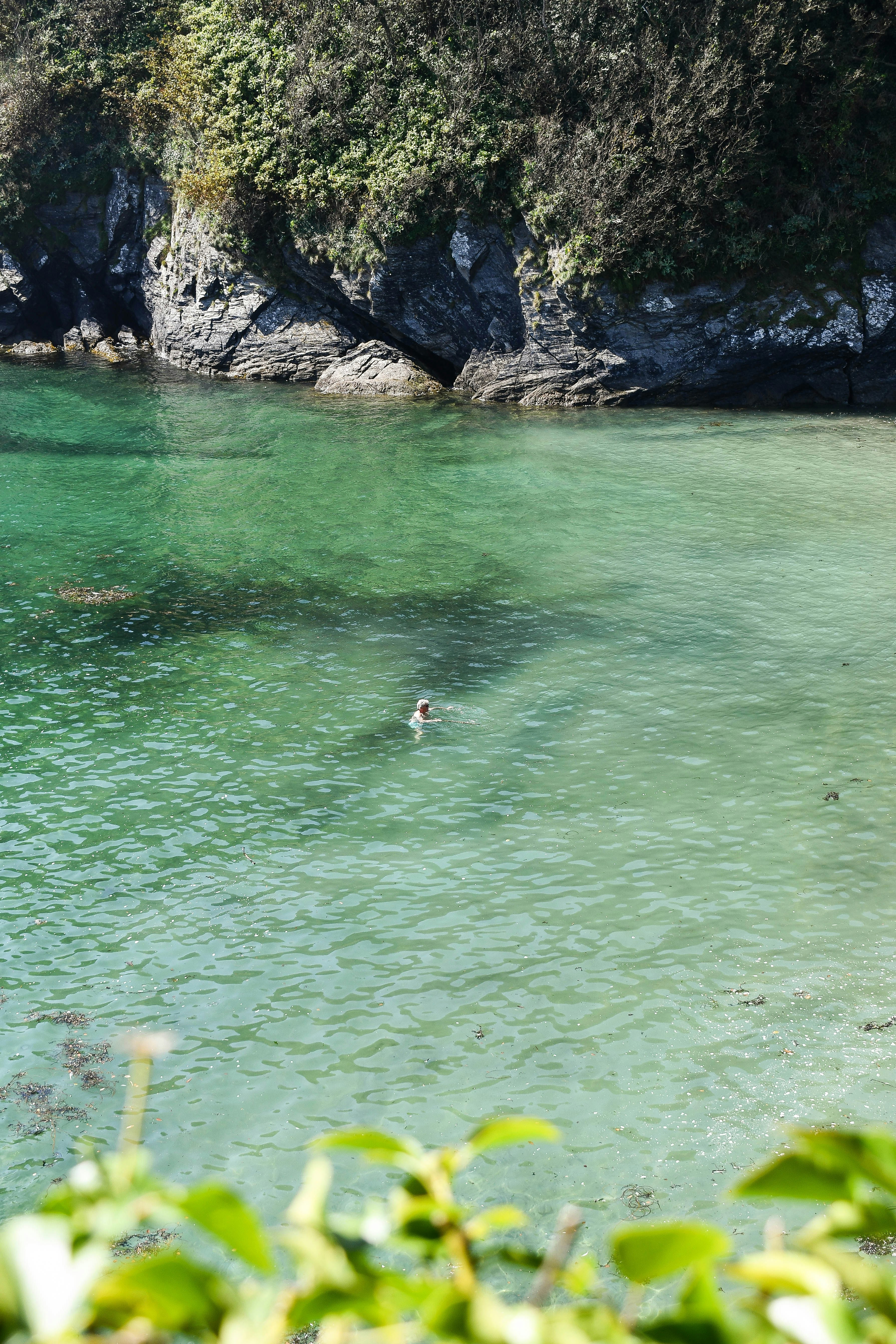 Emerald Pool: A lone swimmer Amid Stone and Sunlit Water