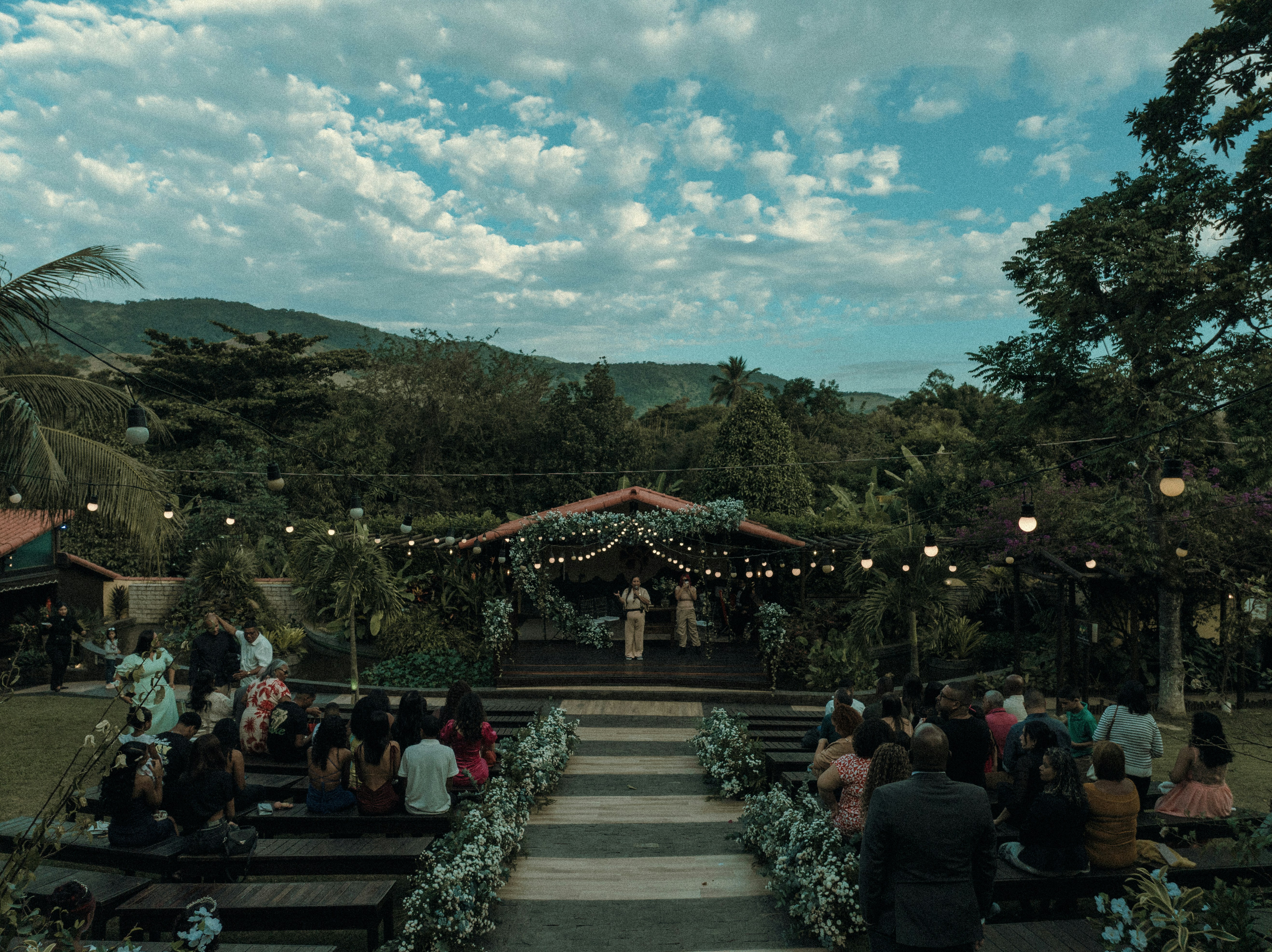 Sunlit Ceremony Aisle: Evening Lights and Shared Moments