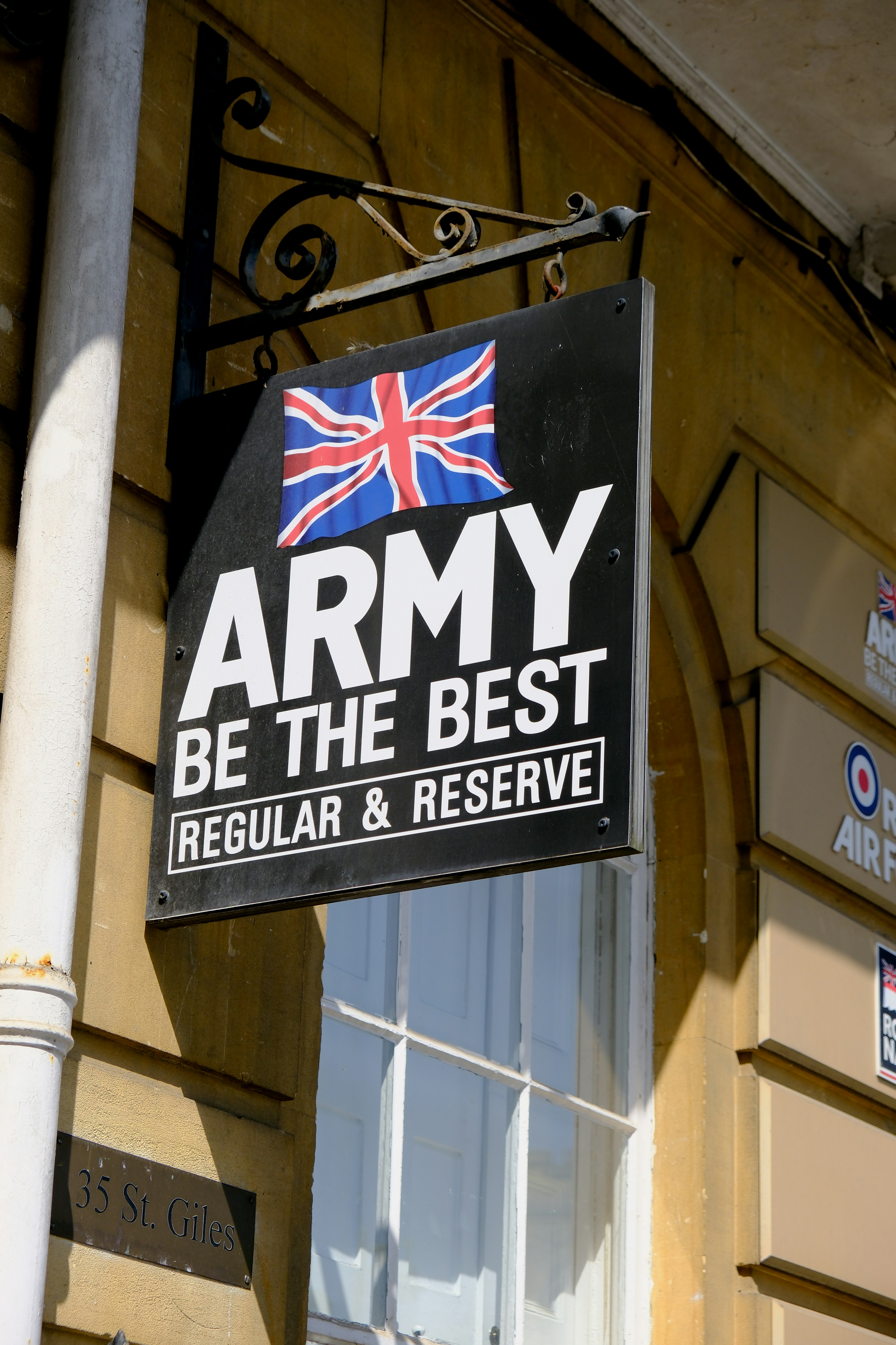 Be The Best: Army Sign Adorned in British Flag Ascending the Yellow Wall