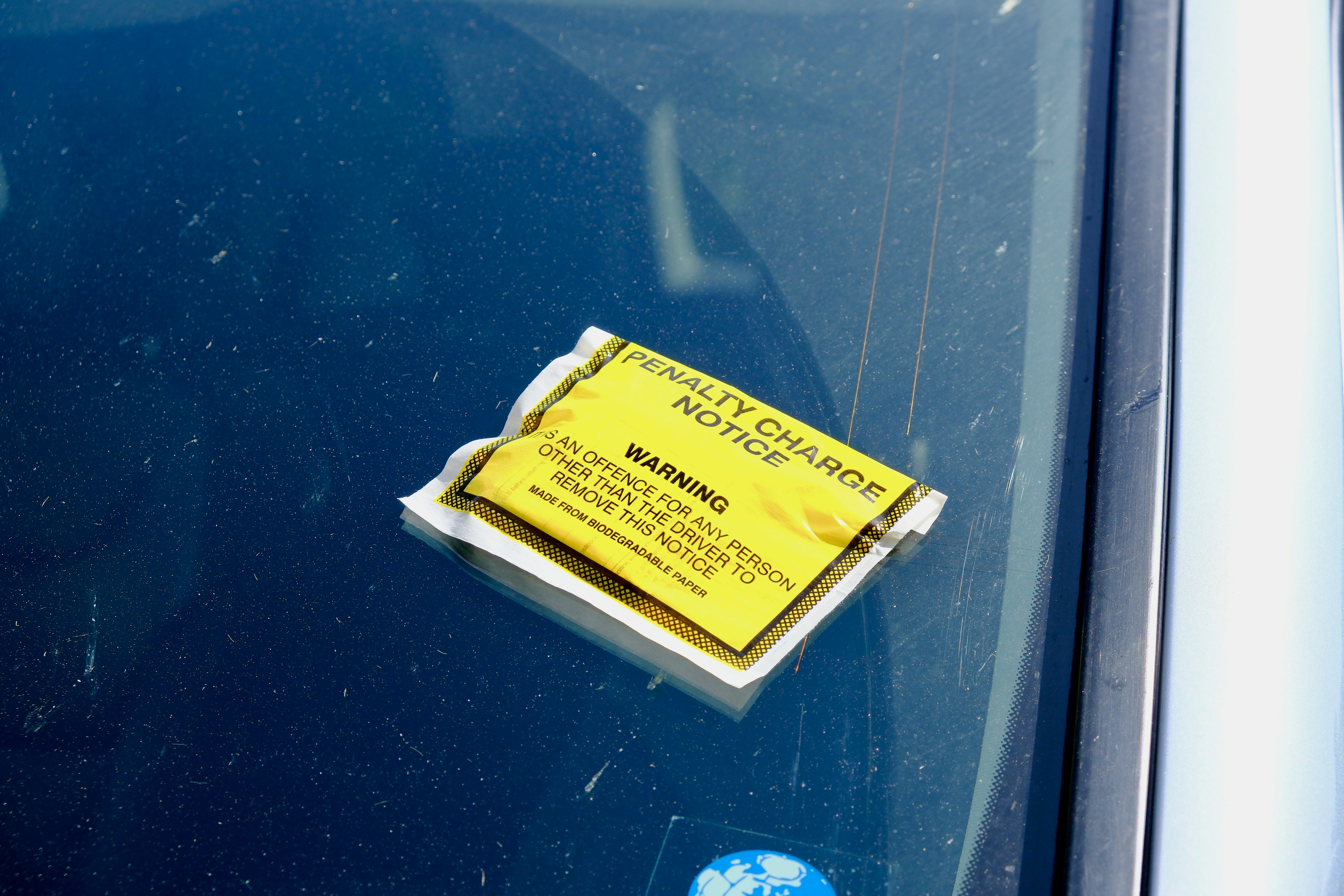 Hidden Message on the Windshield: A Caution Tag on a Dusty Car