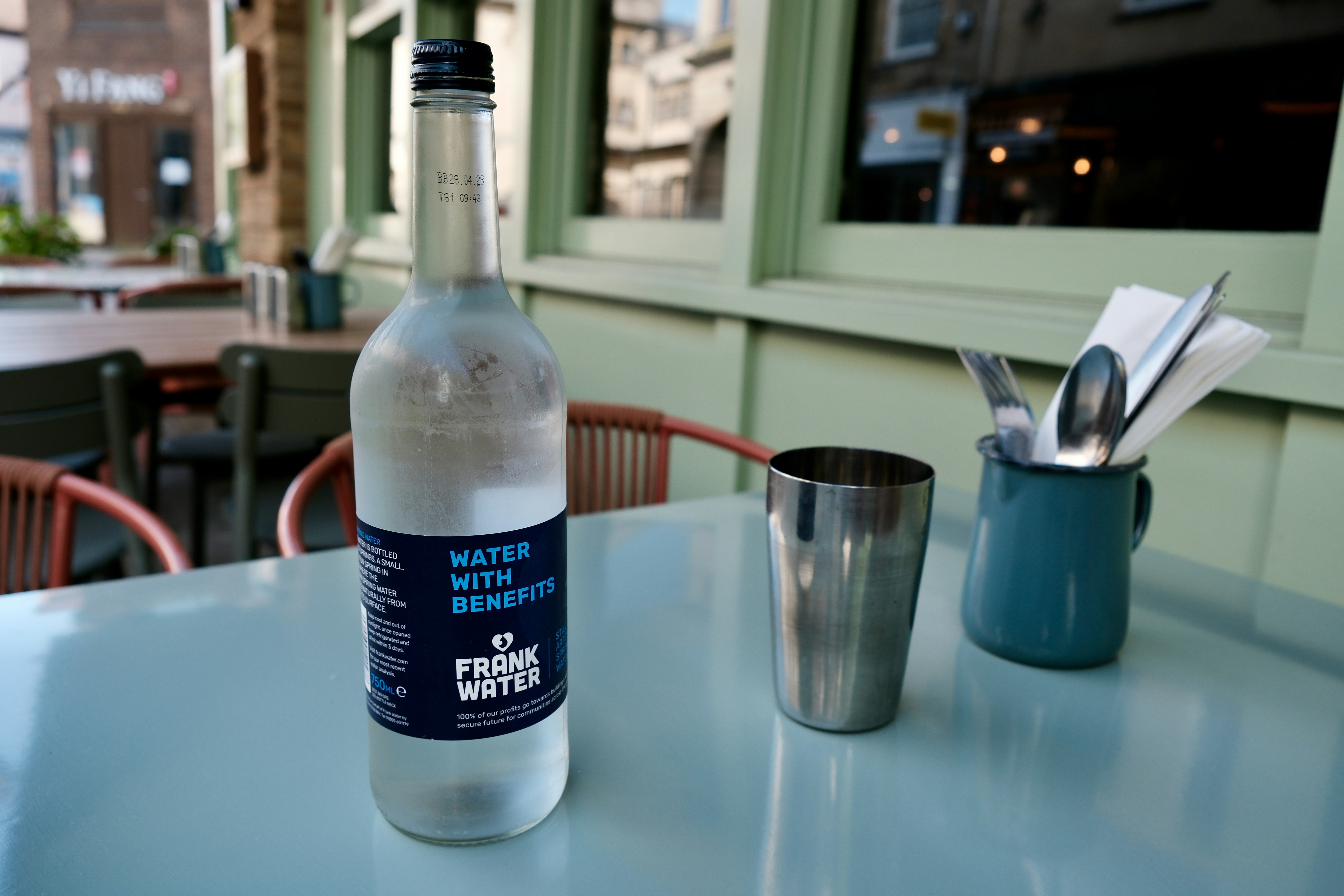 Cold Clarity: A Water Bottle Centered on a Quiet Café Table
