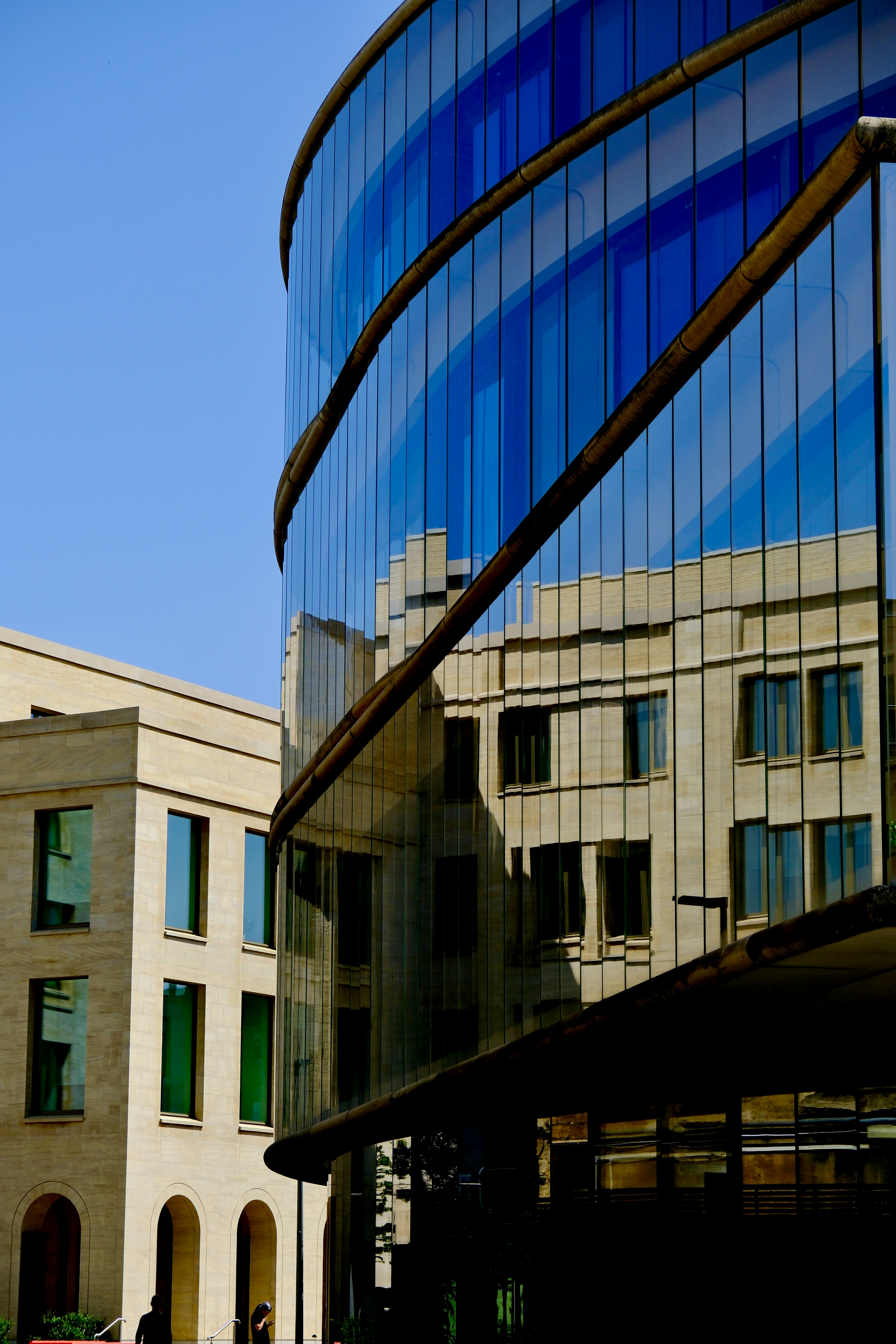 Glass Facade Echoes: A Modern Building Wrapped in Blue Reflections