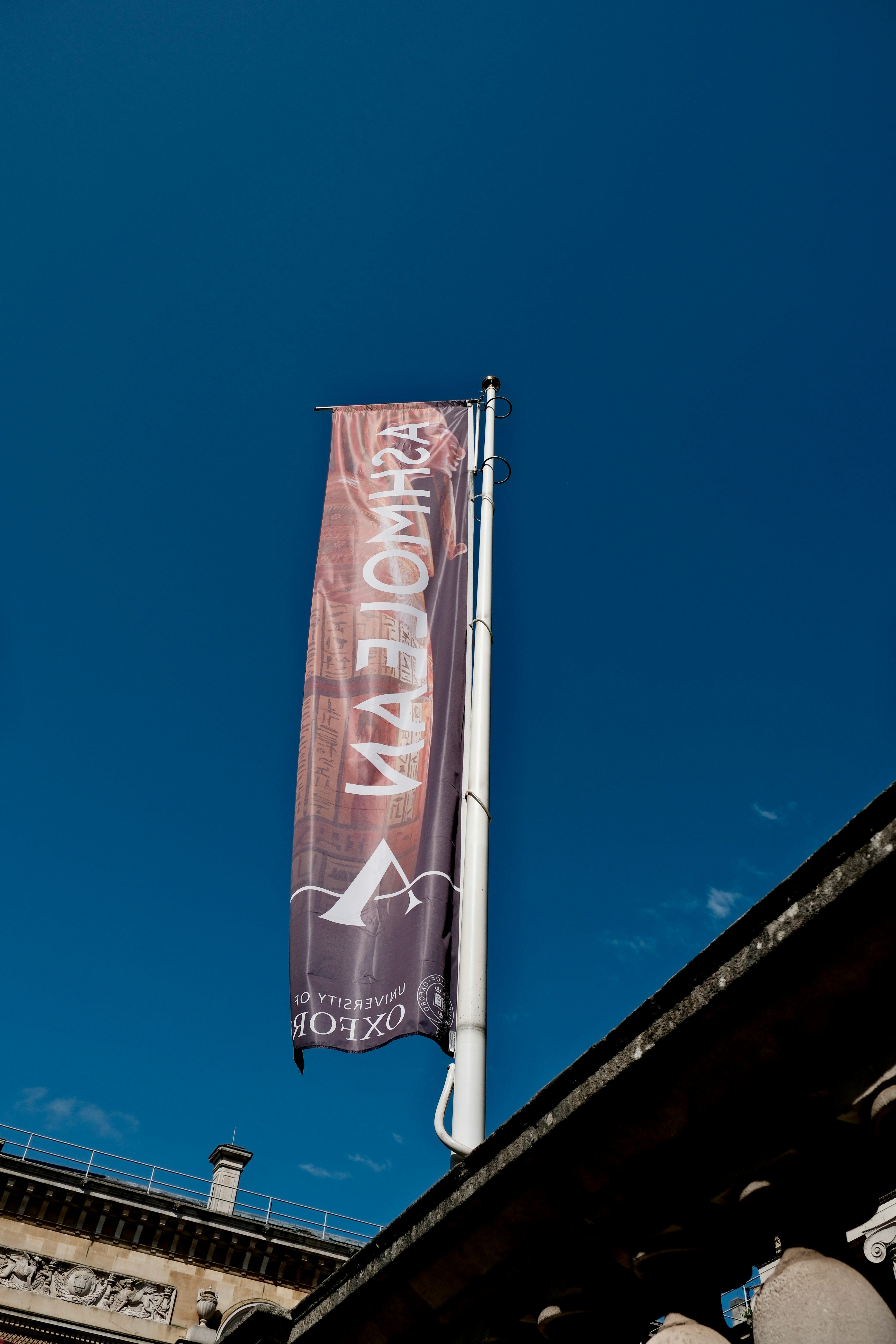 Ashmolean museum flag flying against a clear blue sky.
