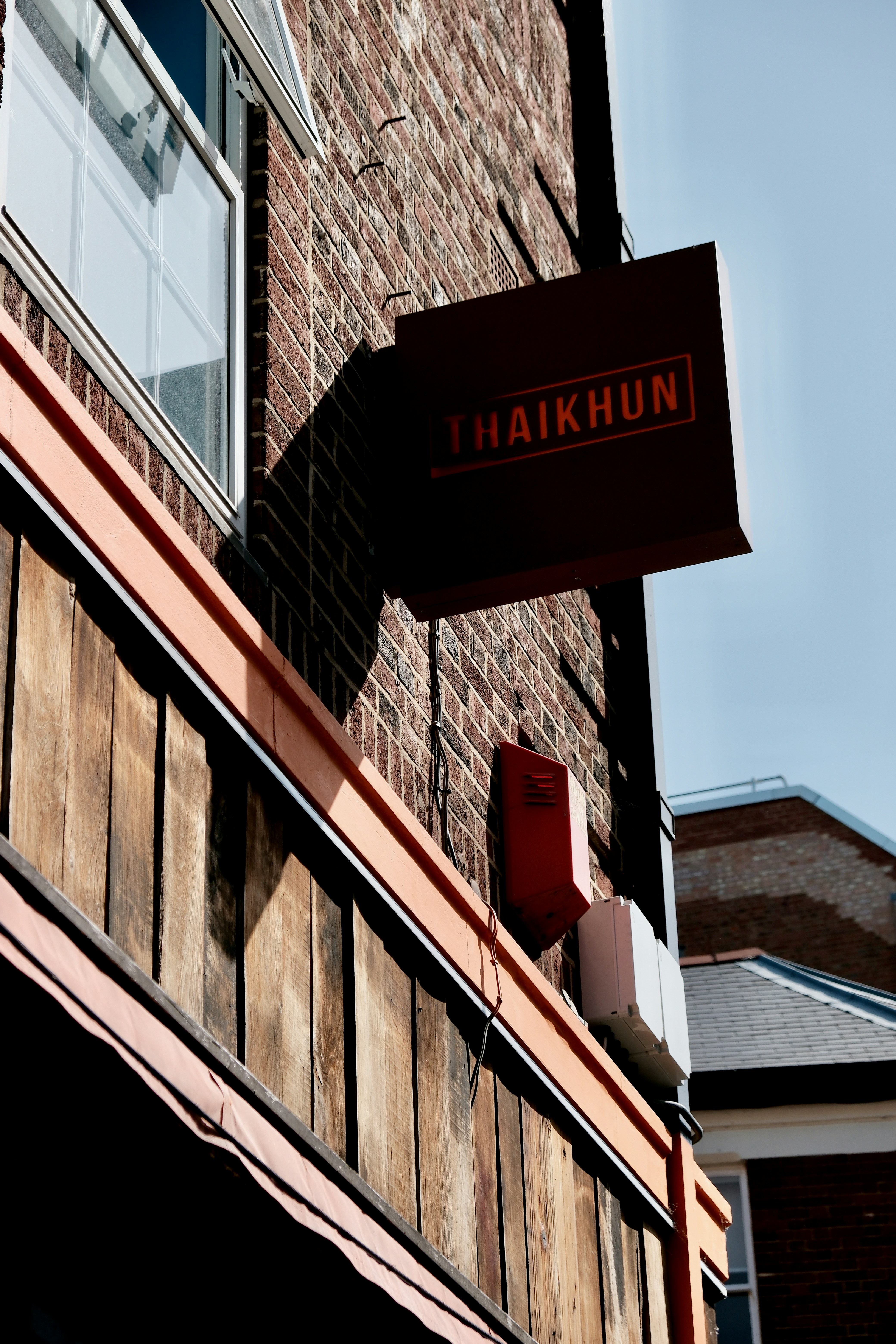 Thaikhun Sign Nook: Brick Facade and Steel Shadow