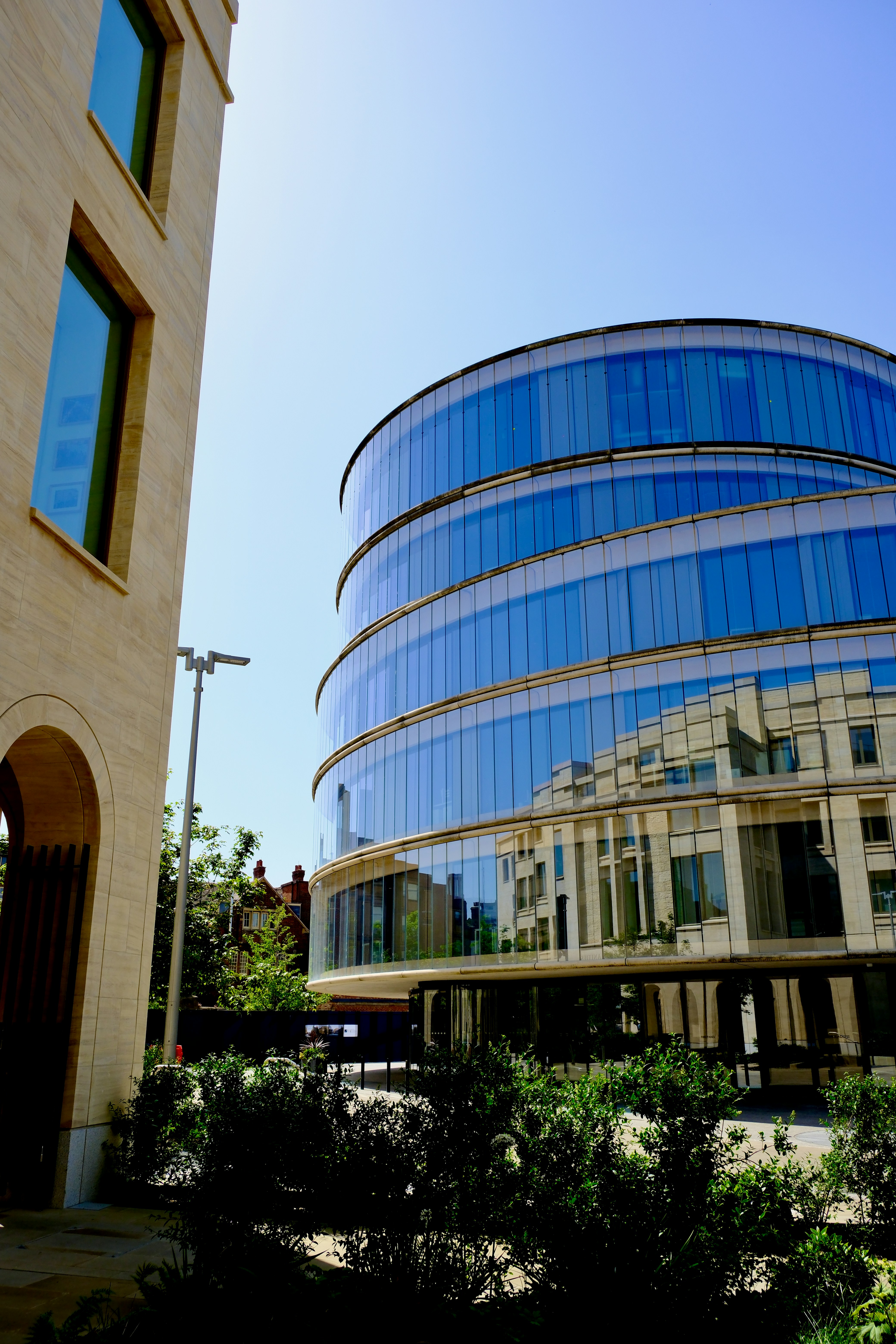 Glass Ringed Tower Rising Over Shaded Courtyard