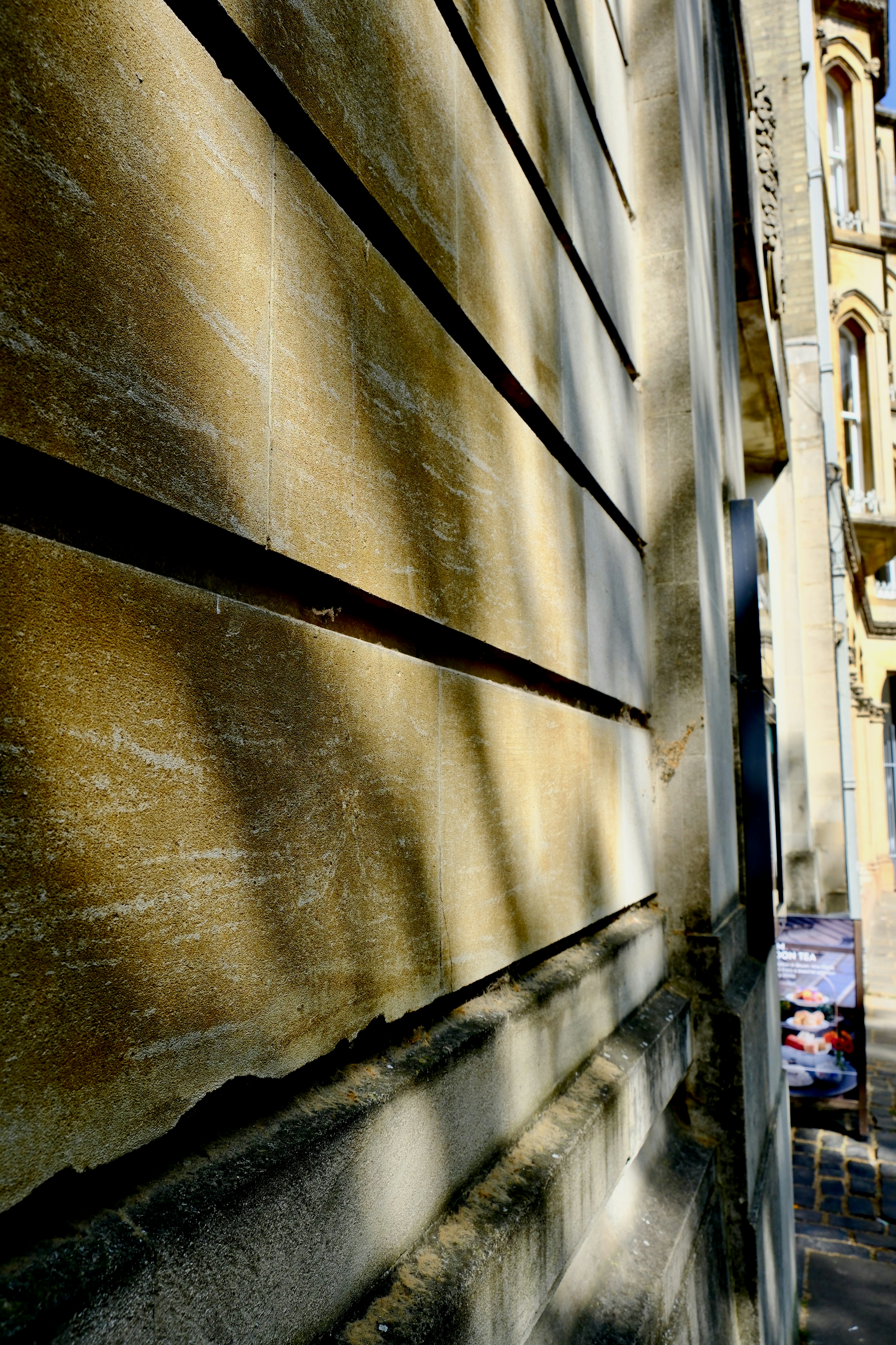 Stone Facade in Narrow Alley: Long Shadows and Golden Light
