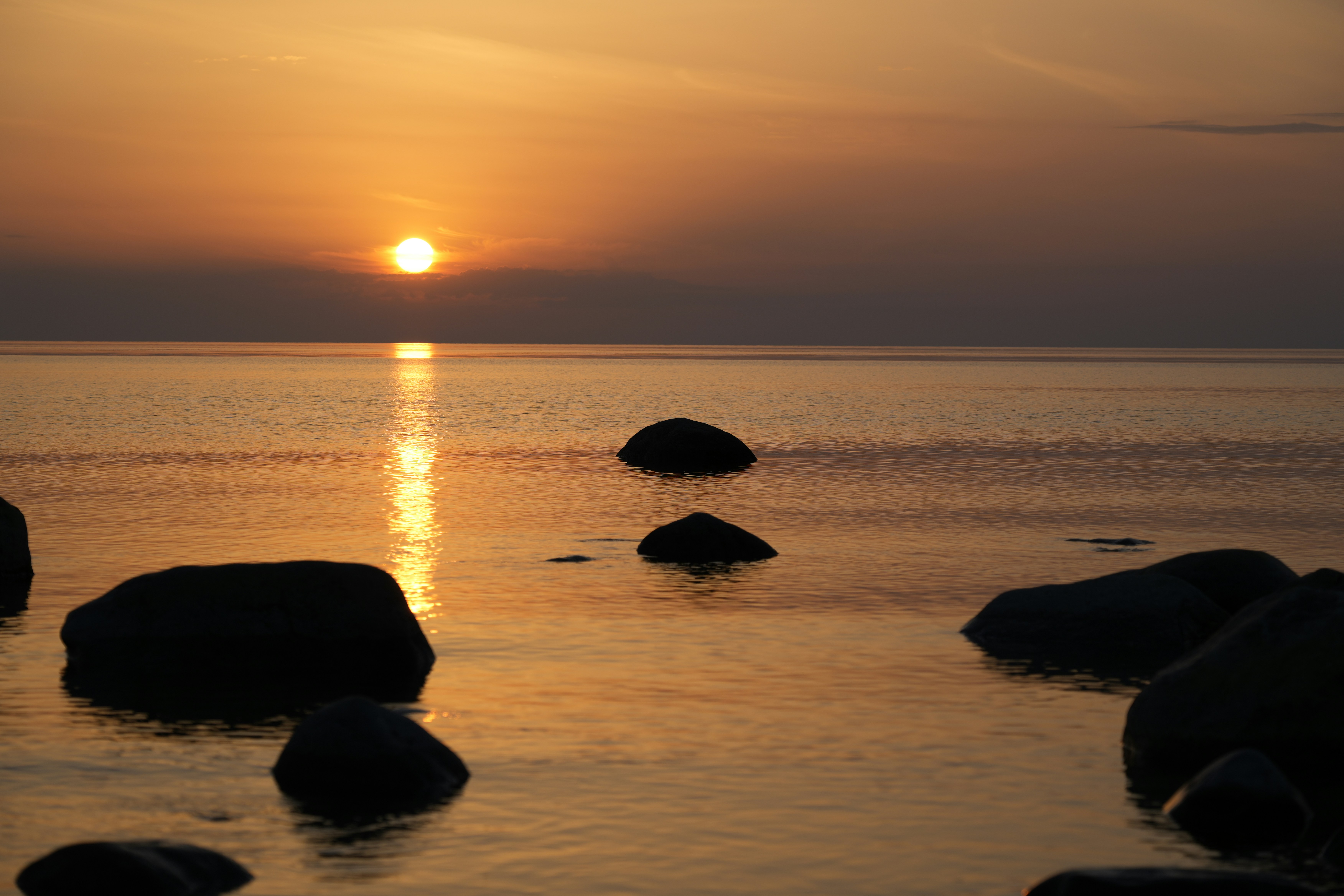 Sunlit Ripples and Silent Rocks at Dusk