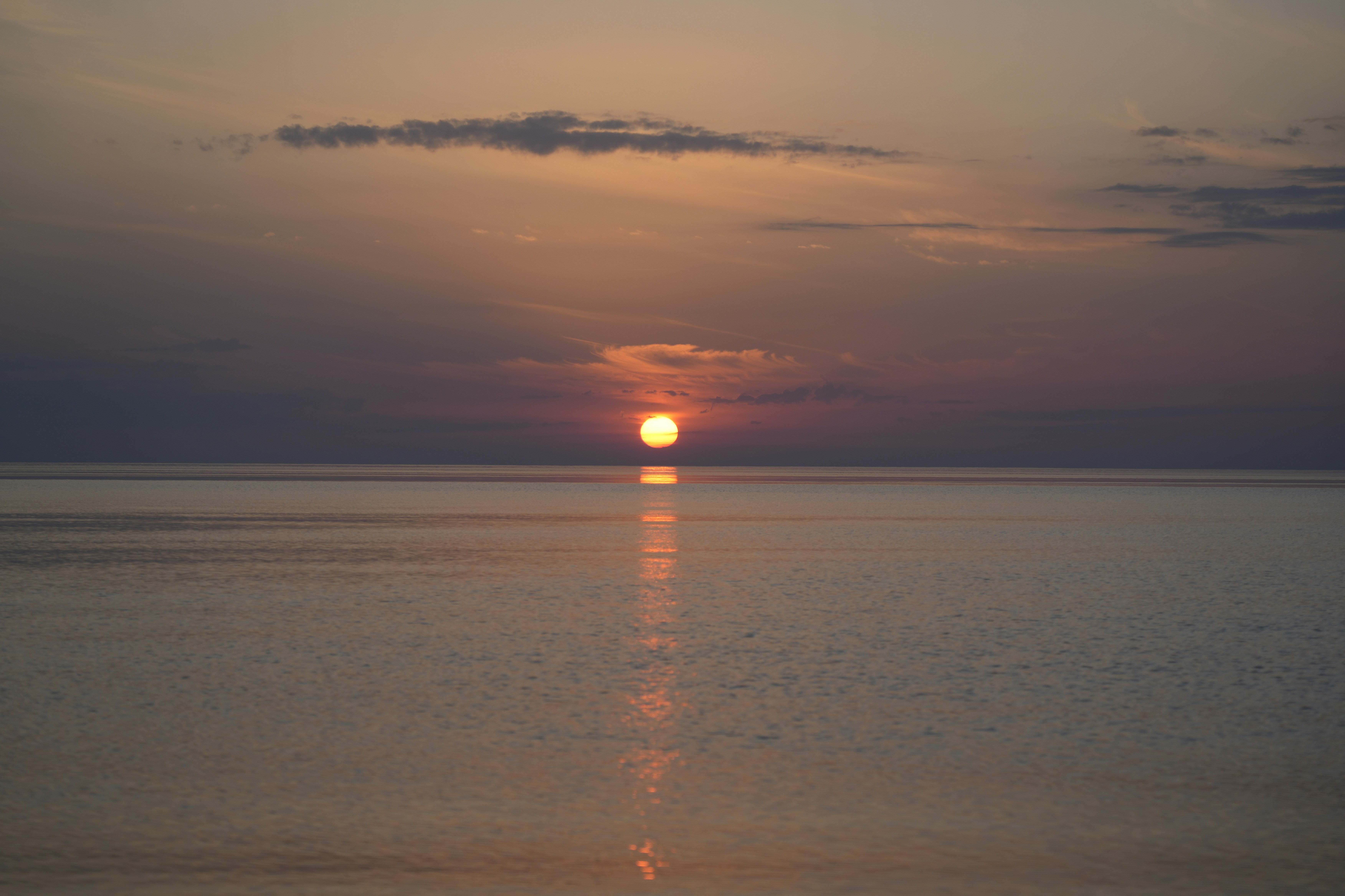 Sunlit Horizon: A Quiet Moment at Dusk Over Calm Waters