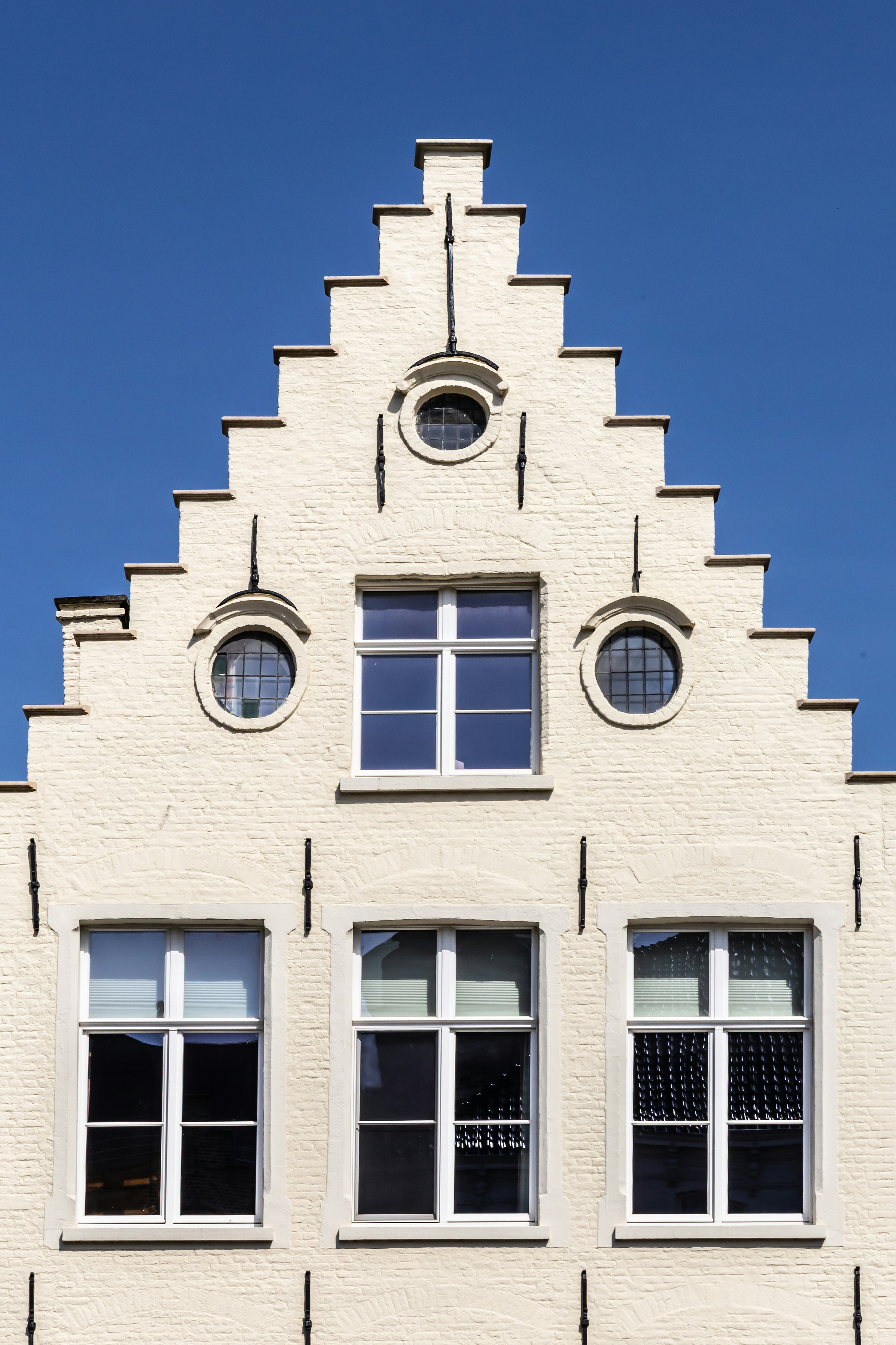 Symmetrical gabled facade with stepped tiers against a clear blue sky