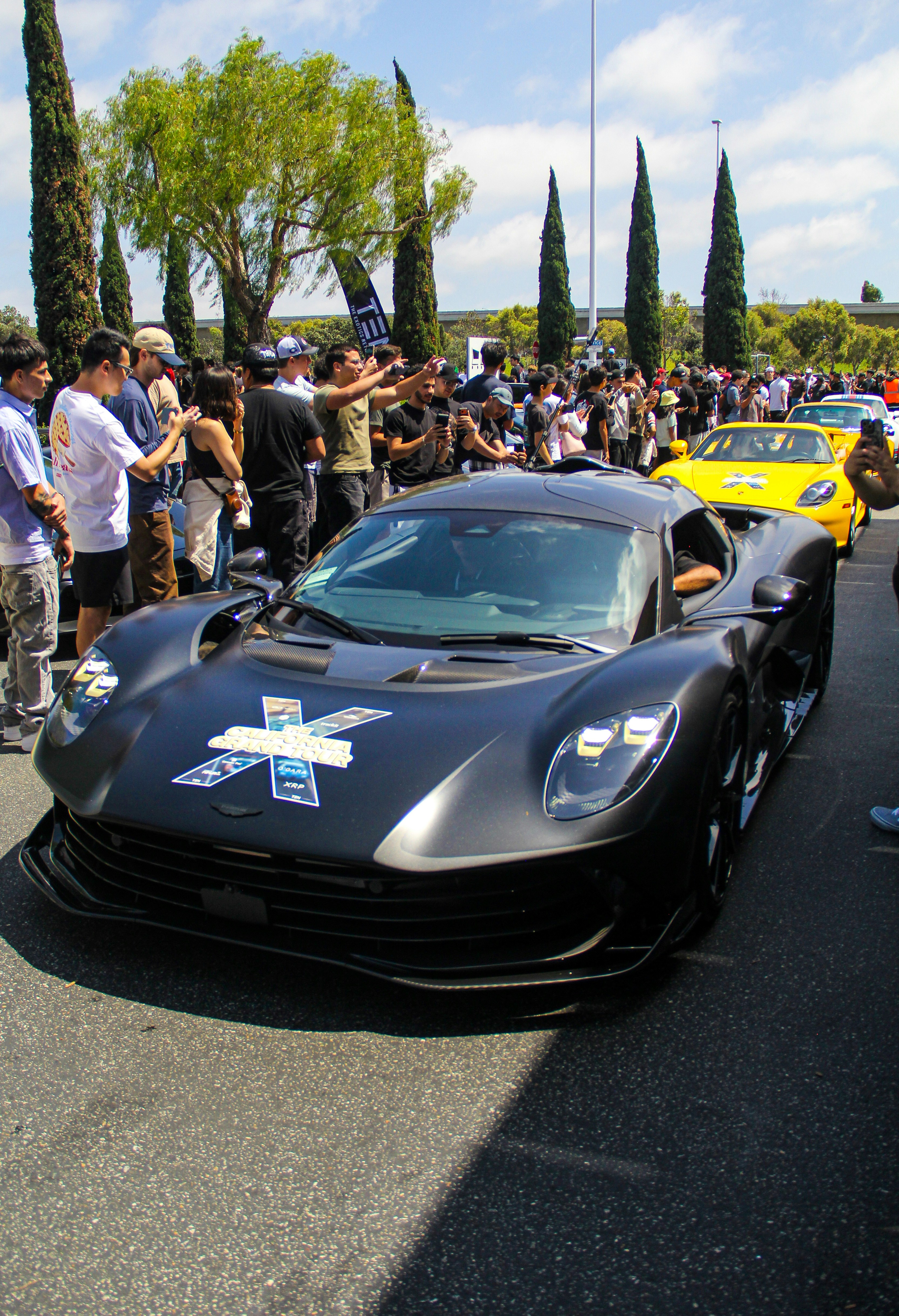 Mamba at the Meet: A Black Ferrari Silhouetted by a Crowd