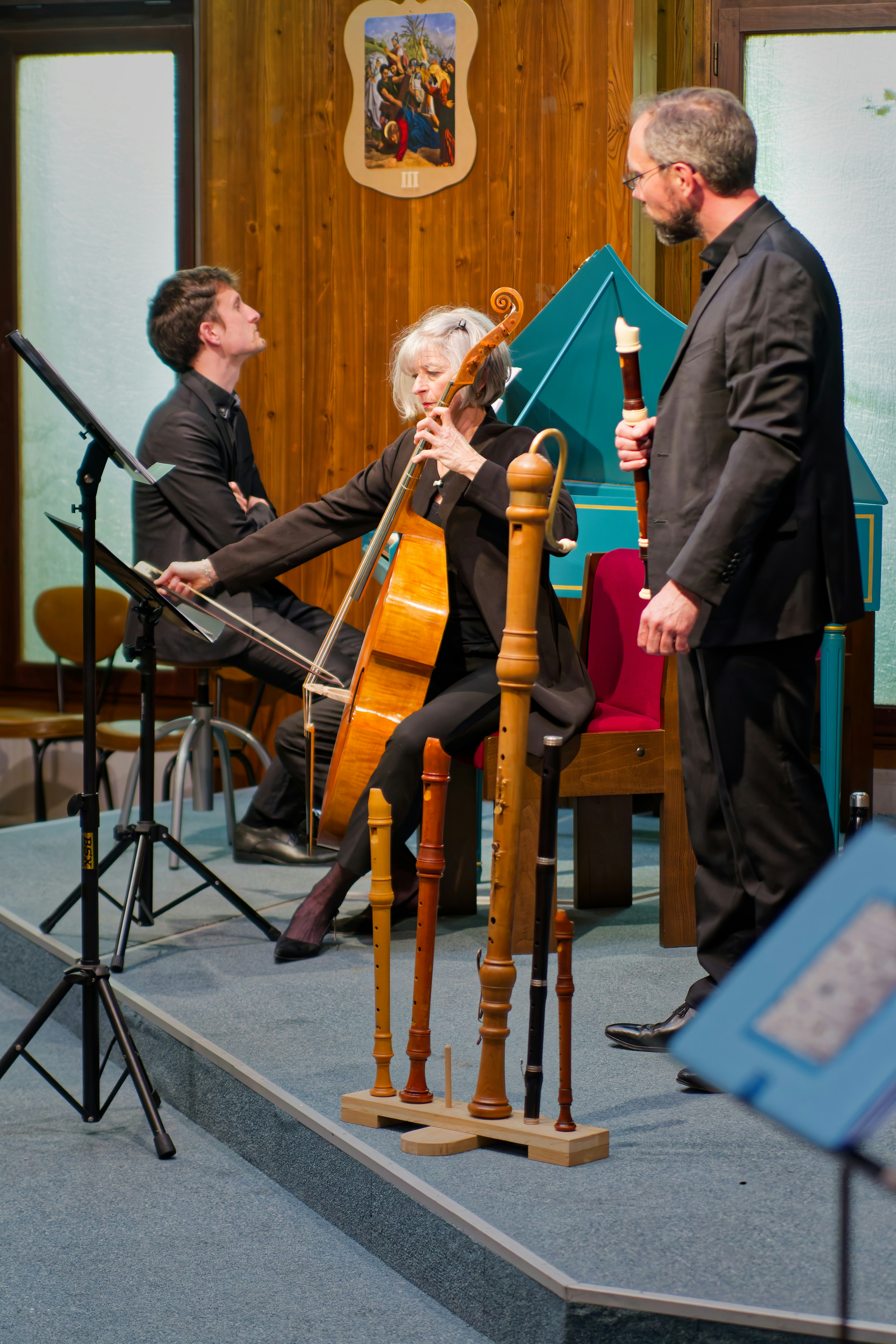 Cellist in the Spotlight: A Trio of Strings on a Wooden Stage