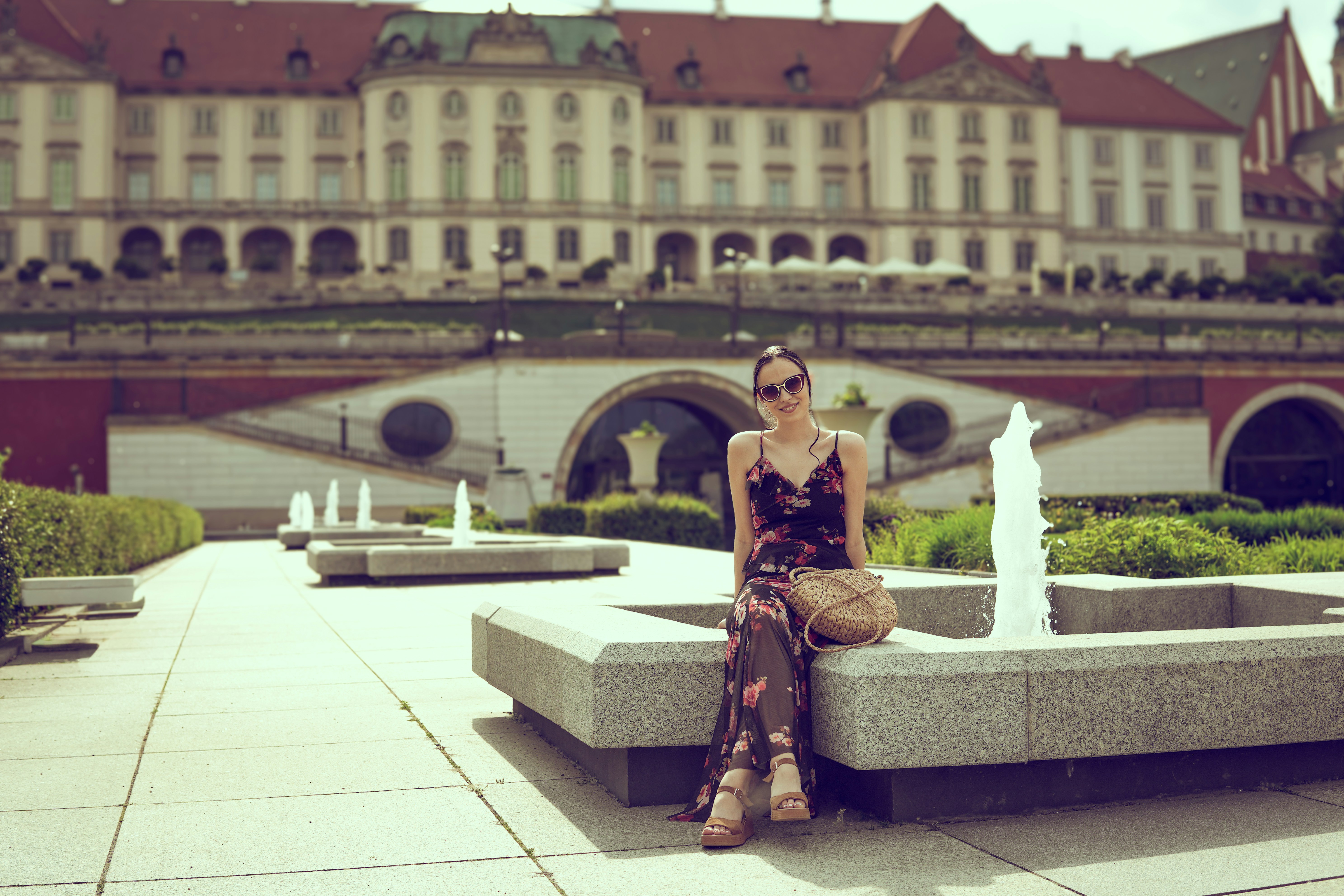 Courtyard Quiet: A Seated Traveler Beneath Historic Arches