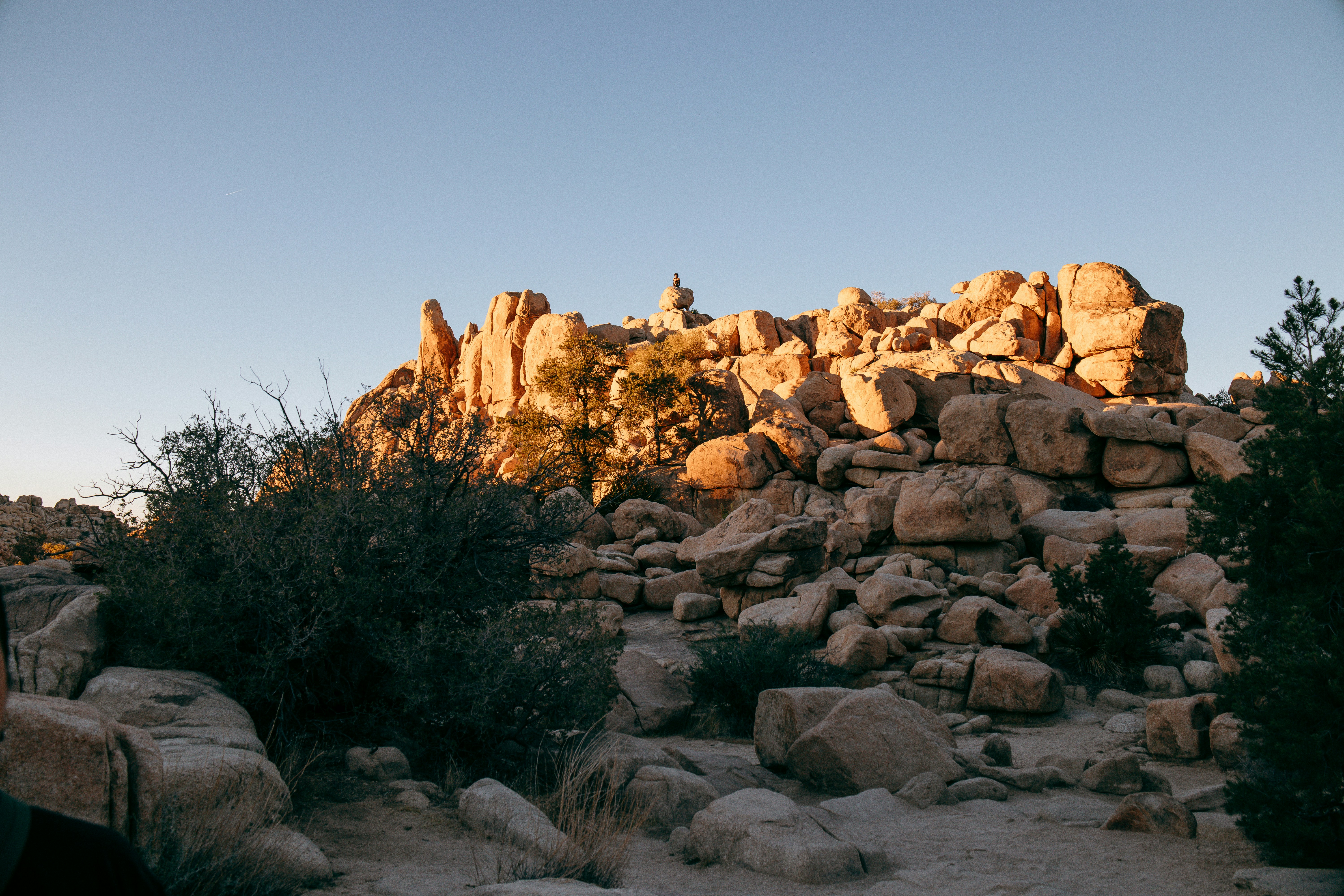 Sunlit Sentinel: Rugged Rock Formations Under a Clear Desert Sky
