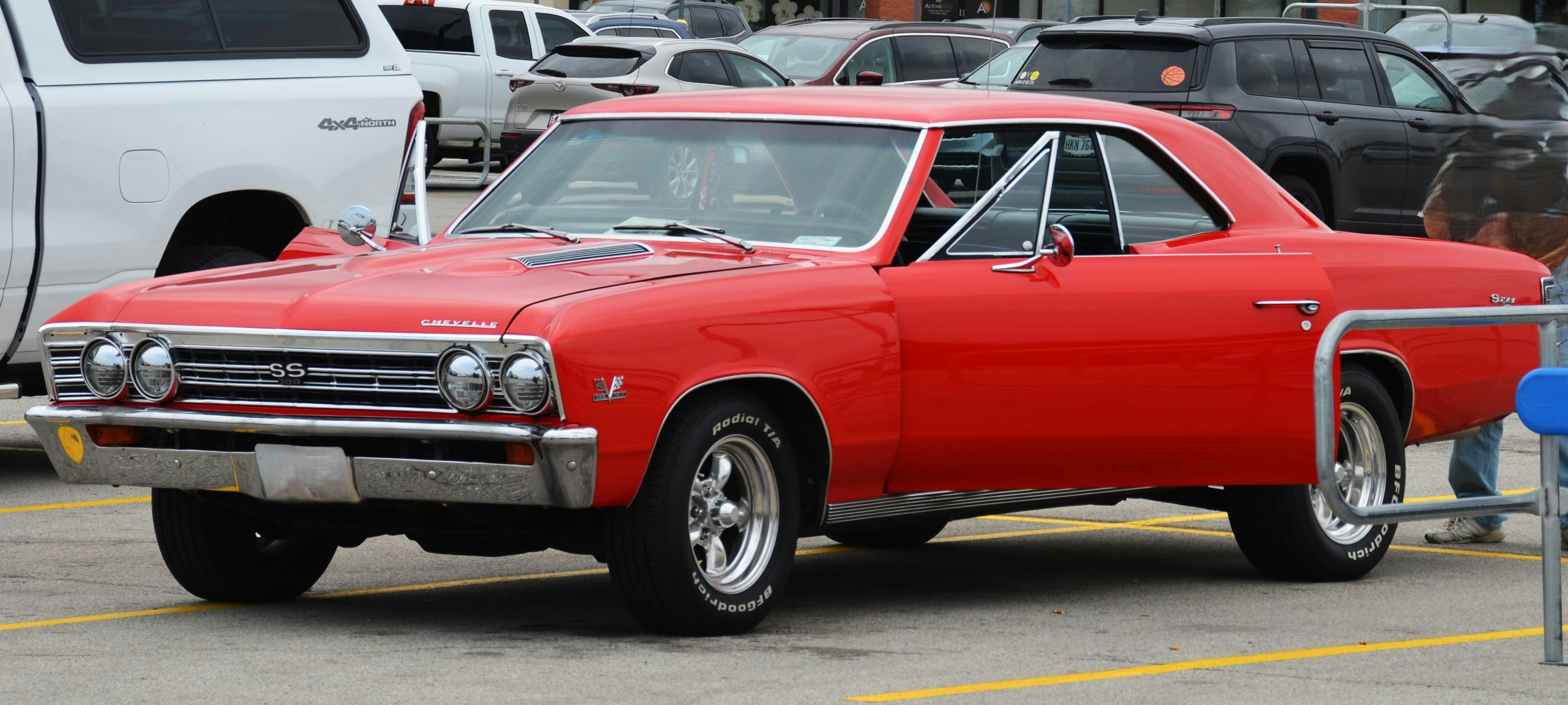 Red Muscle Classic: A gleaming 1960s Chevrolet El Camino in a parking lot