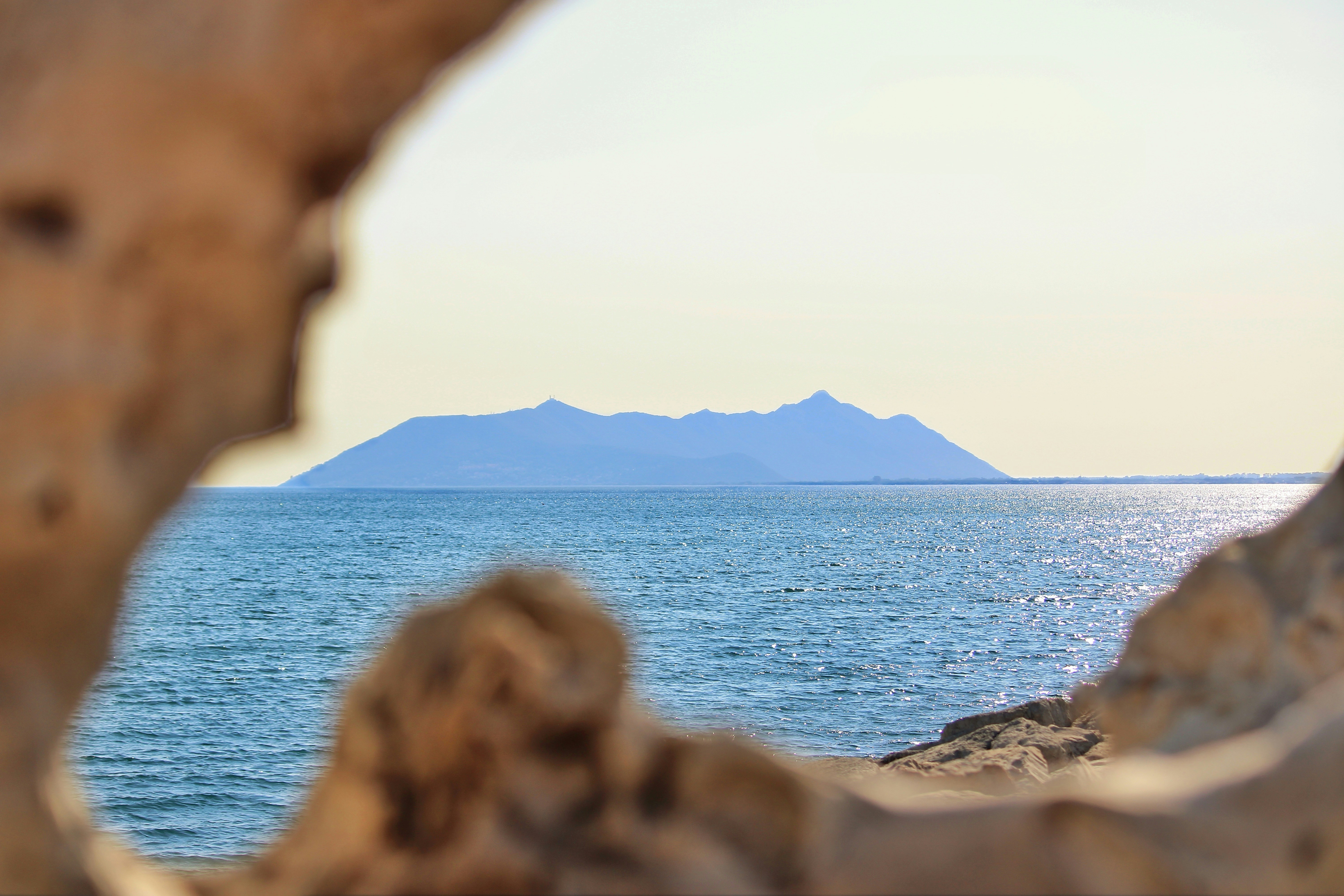 Isolated Island Silhouette Across Calm Azure