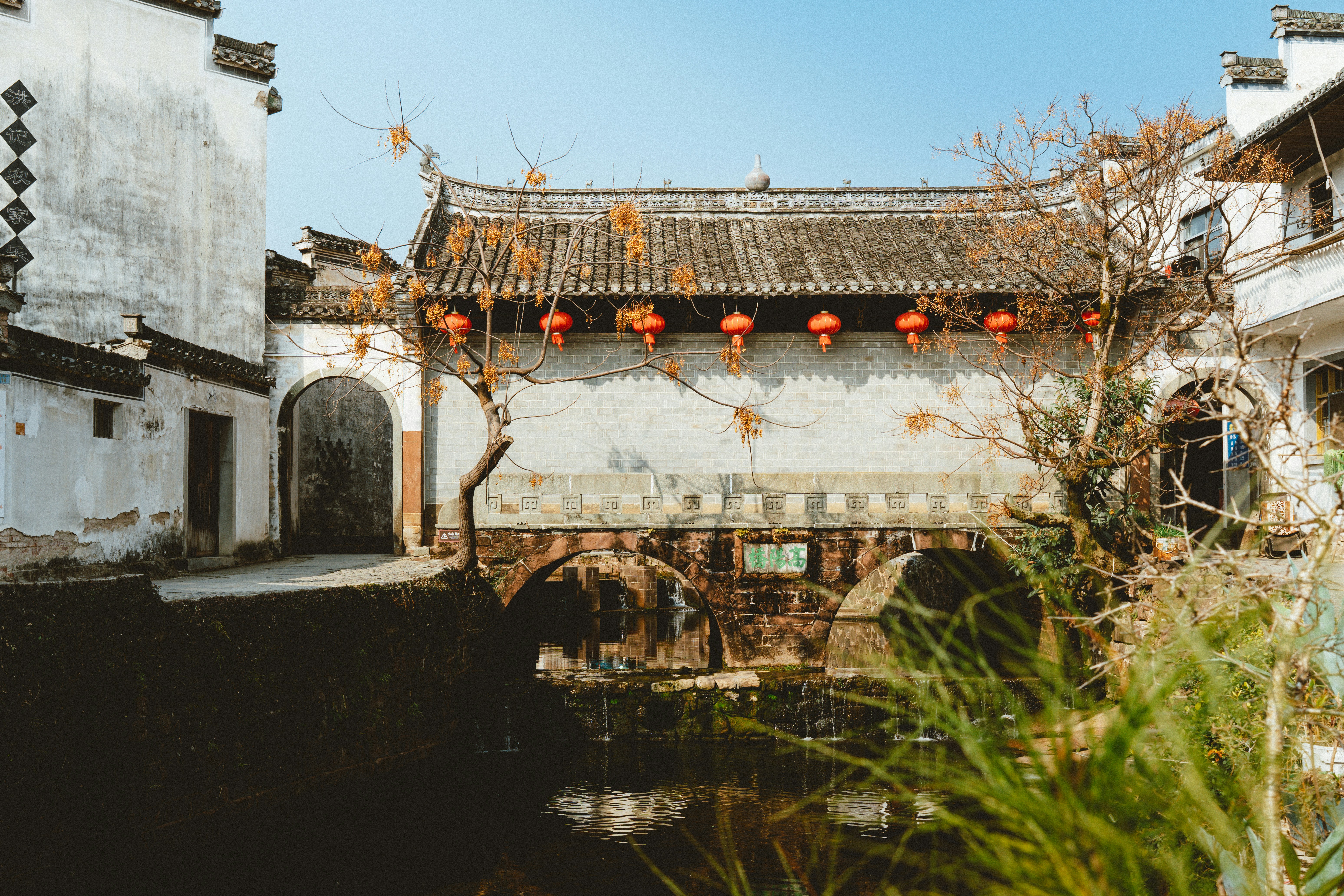 Bridge of Lanterns Over Quiet Canal in Autumn Village