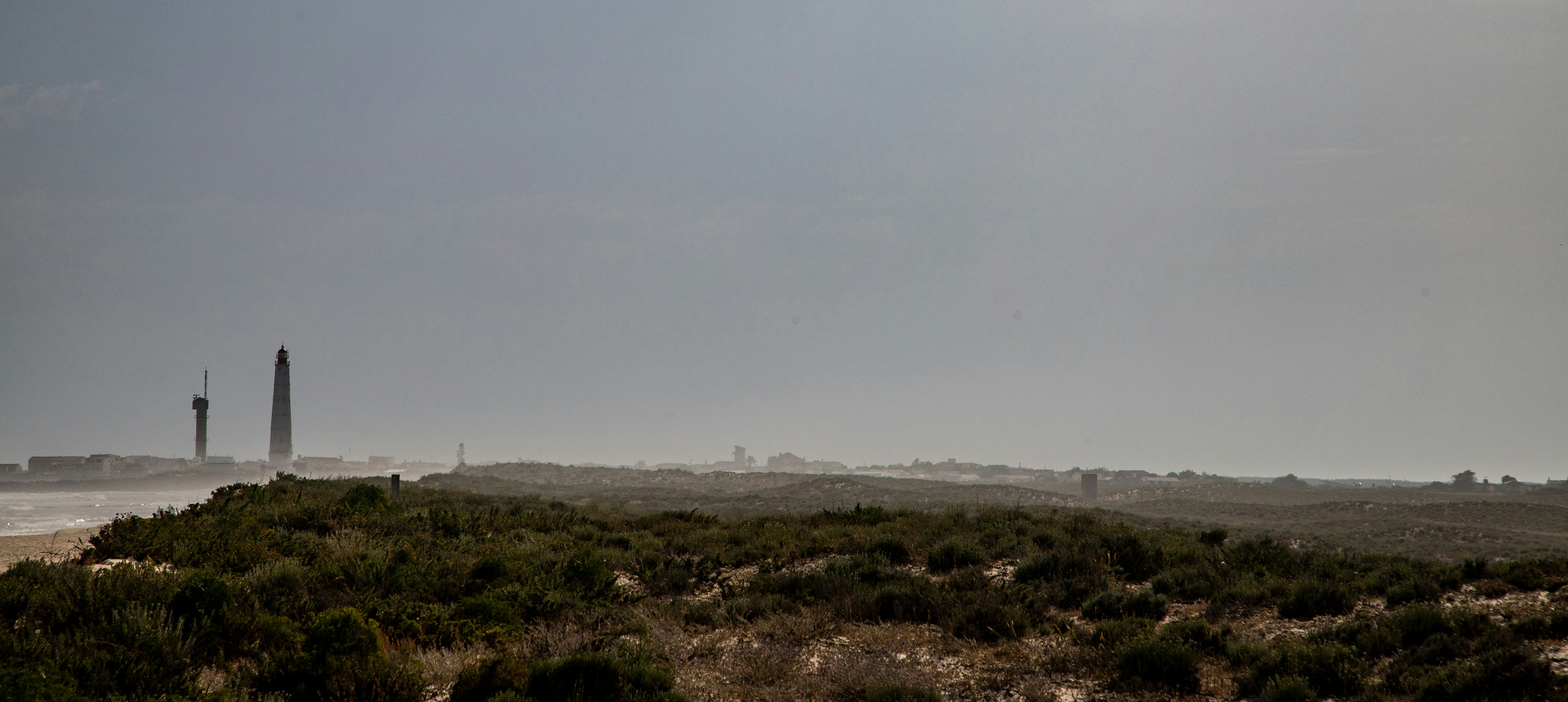 Distant Beacon: A Wind-Swept Horizon with a Lone Lighthouse