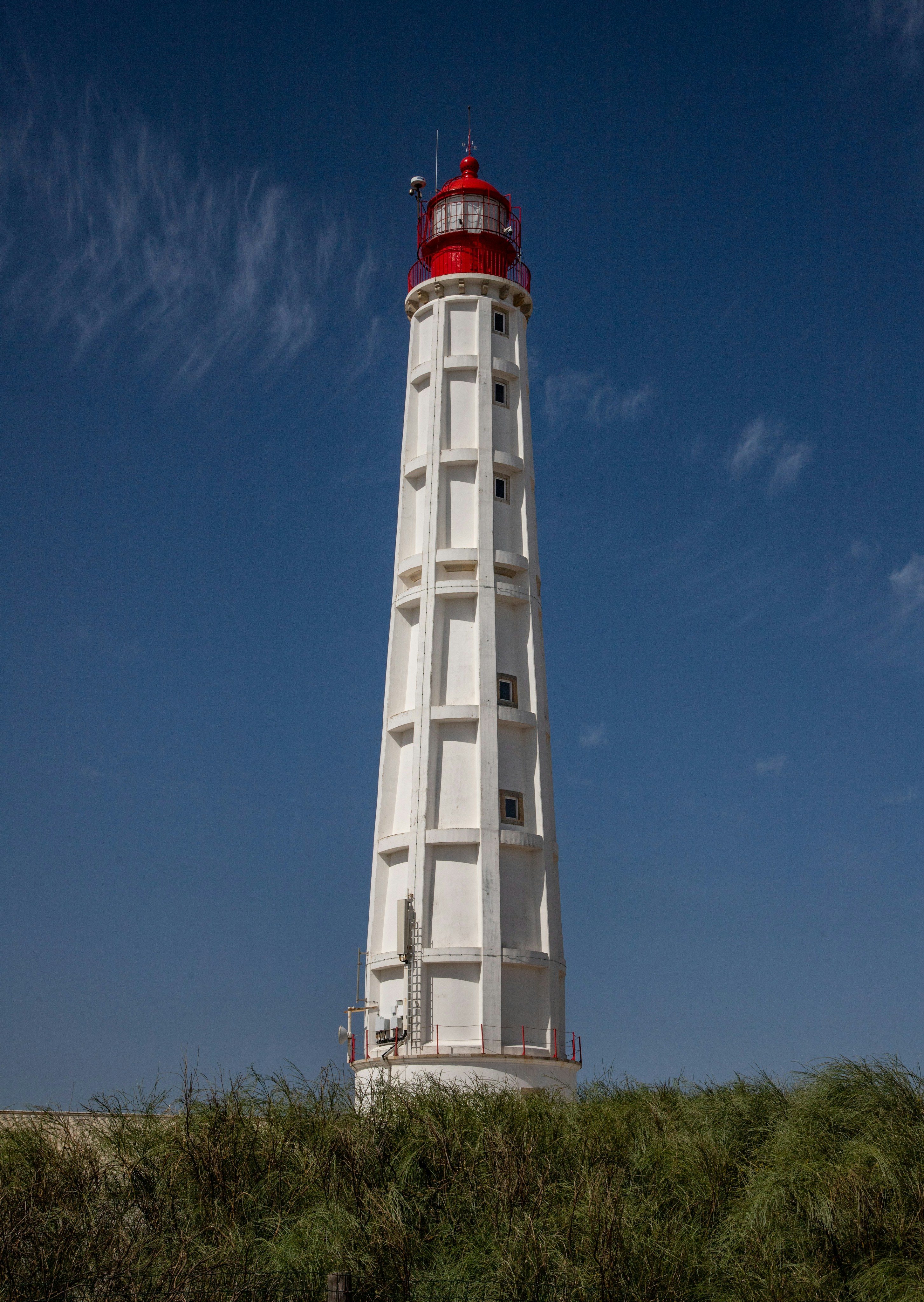 Beacon on a Tall White Shaft: A Coastal Lighthouse Reaching Toward the Sky
