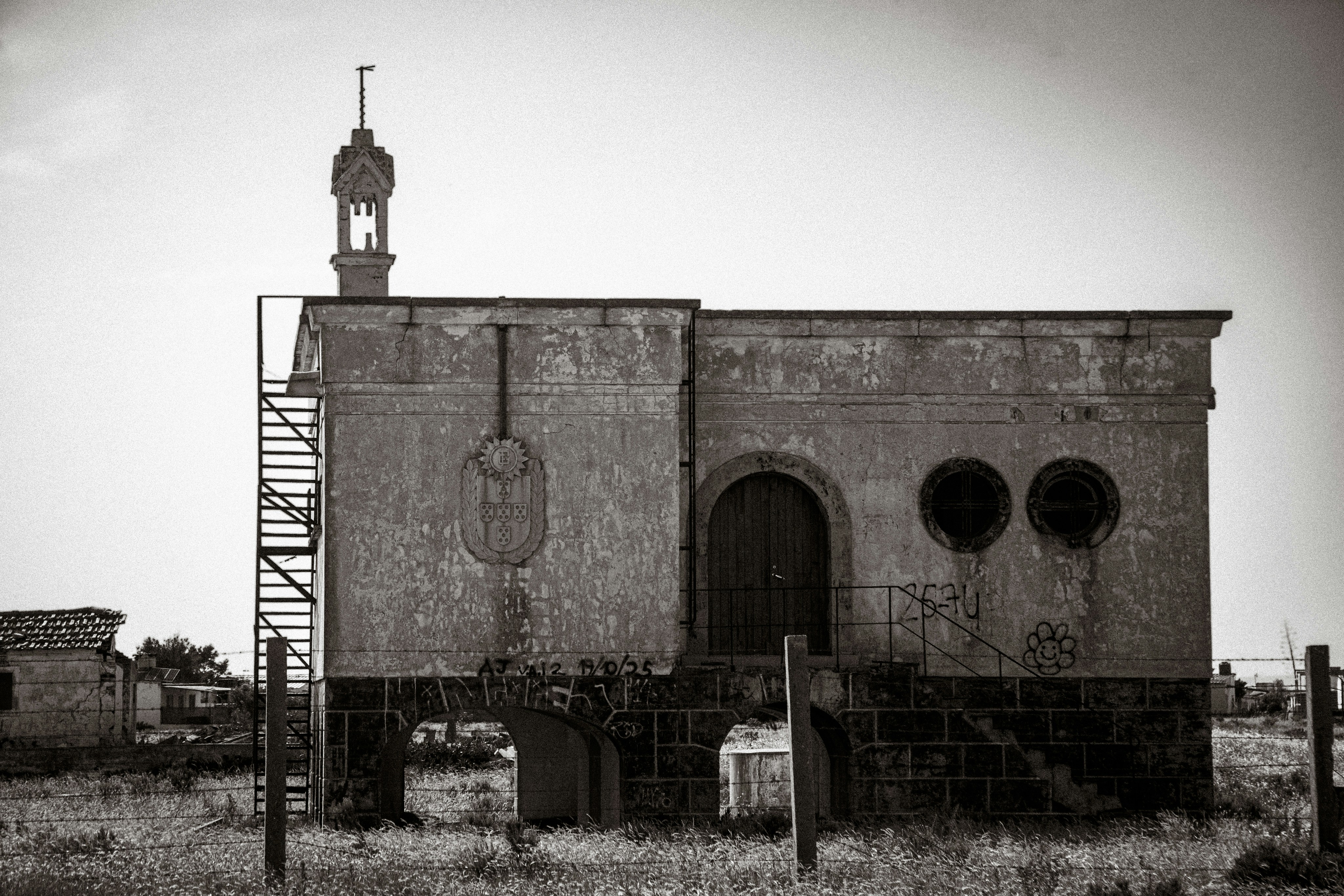 Abandoned lighthouse-keeper’s outpost: a weathered facade sinking into silence