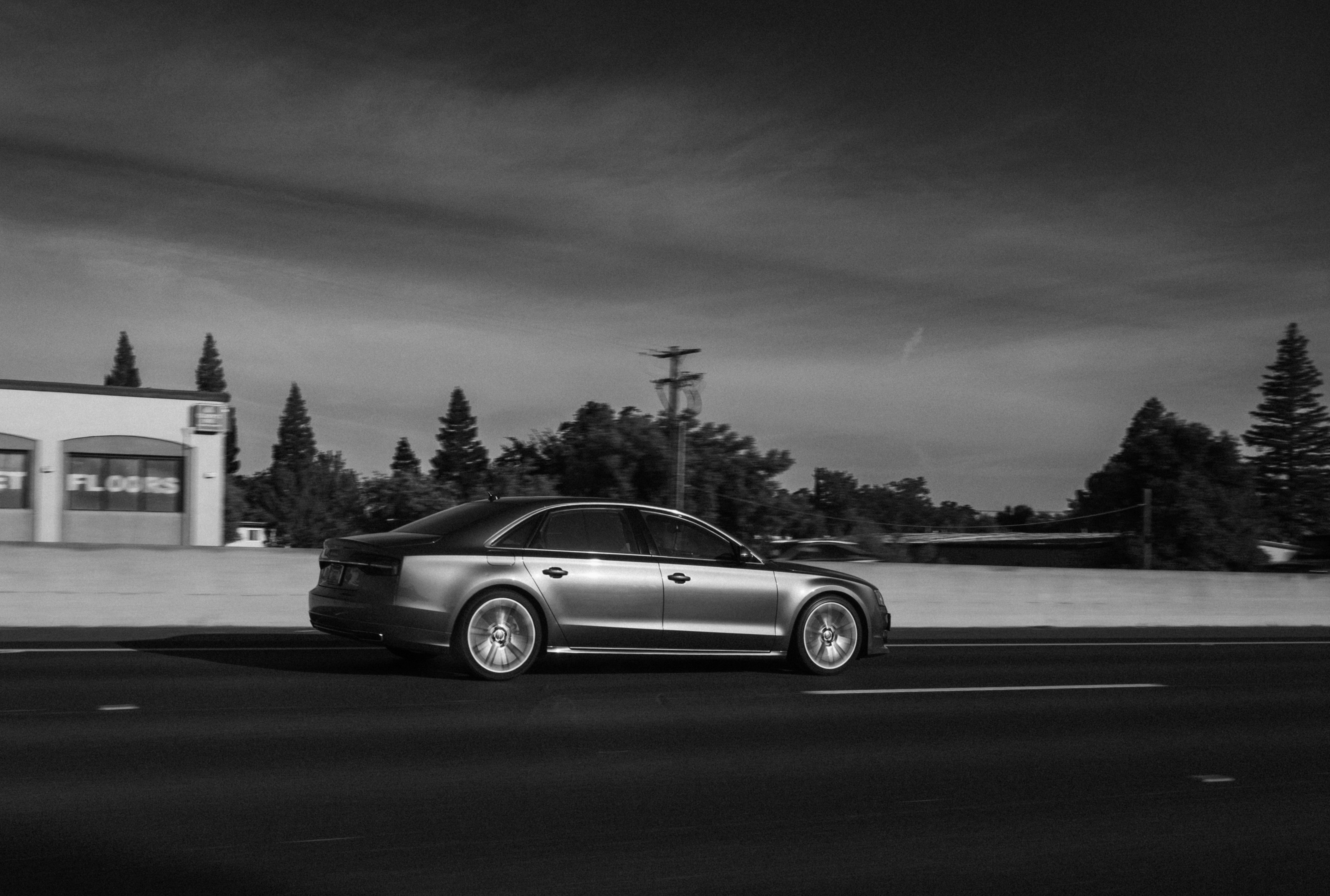A sleek car travels on a highway in monochrome. photo – Free Road Image ...