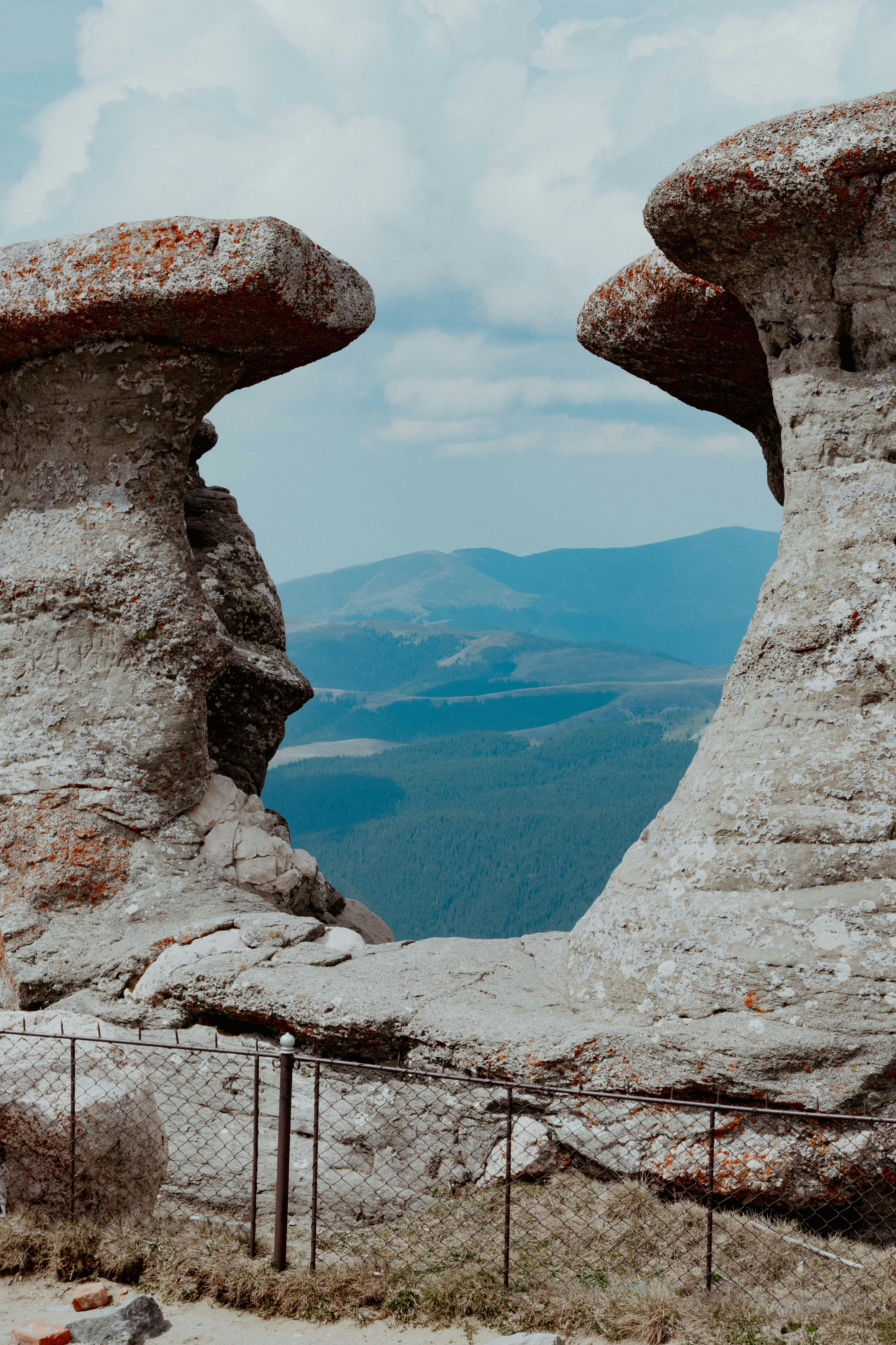 Balanced Window to the Valley: Two rock formations framing distant ridges