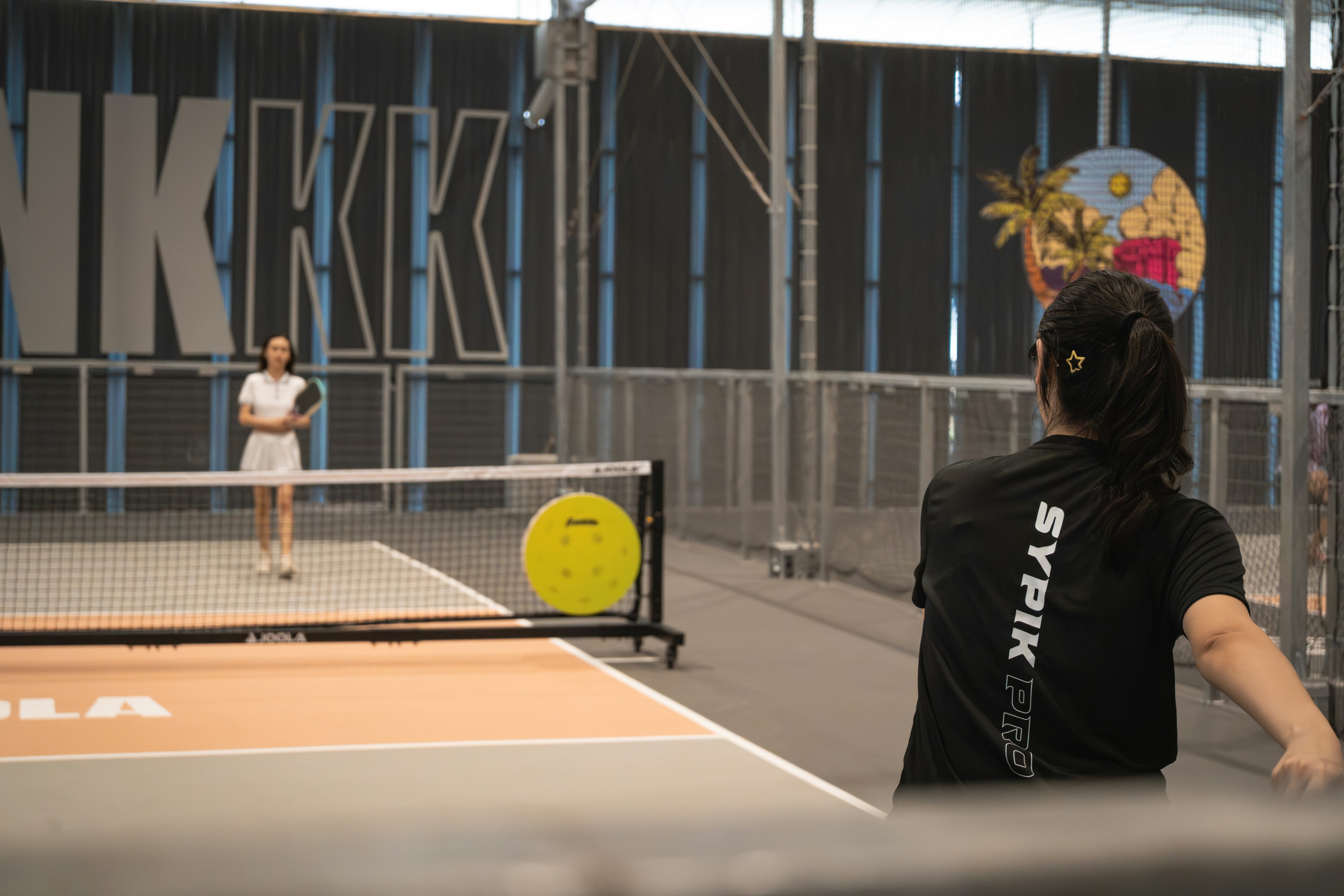 Imminent Return: Opponent at the Net as the Server Whips Toward a Drop Shot