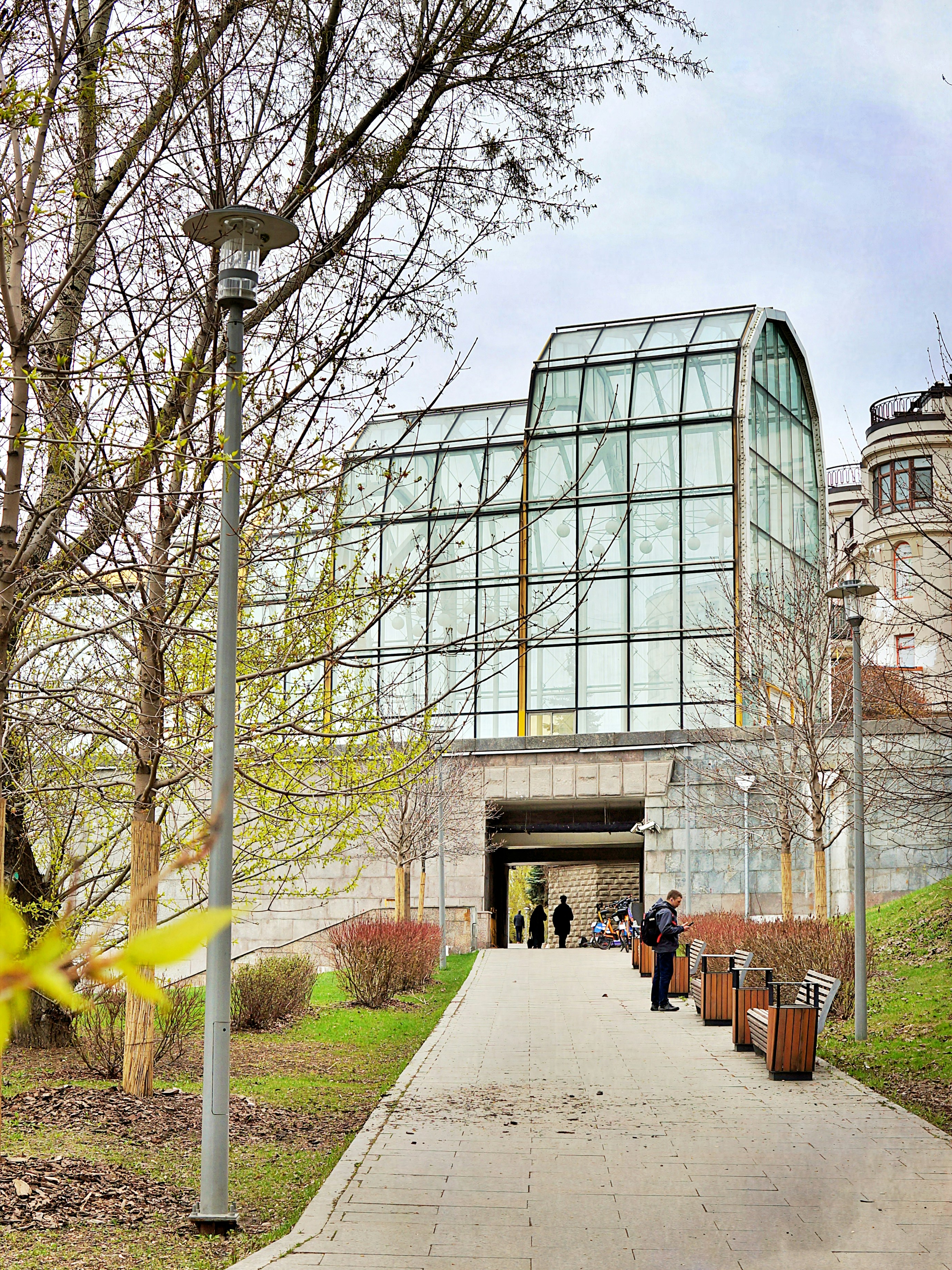 Glass-and-stone Gateway: A Sunlit Campus Walkway Framed by Modern Atrium