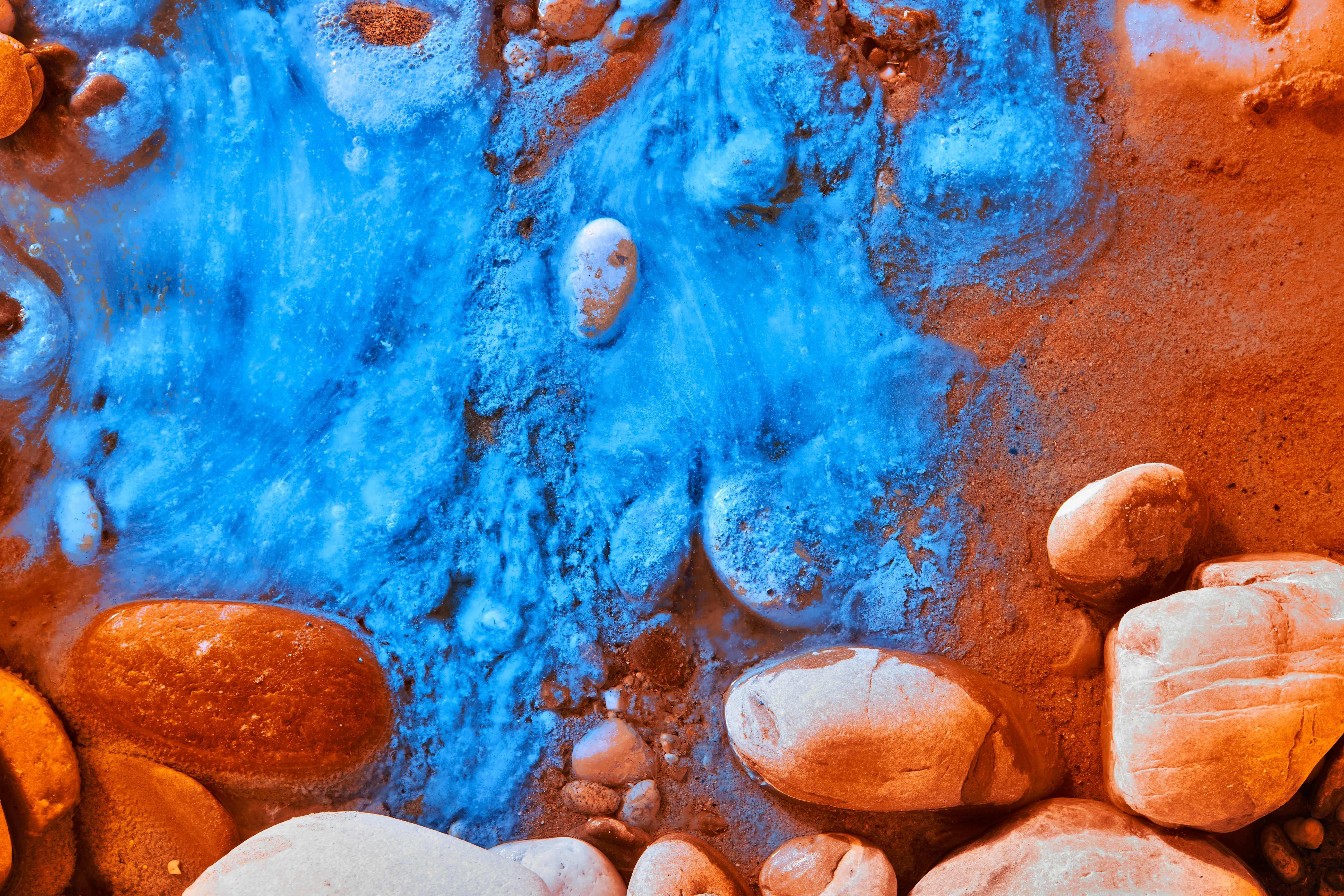 Liquid color clash: cobalt blues meet clay-red riverbed