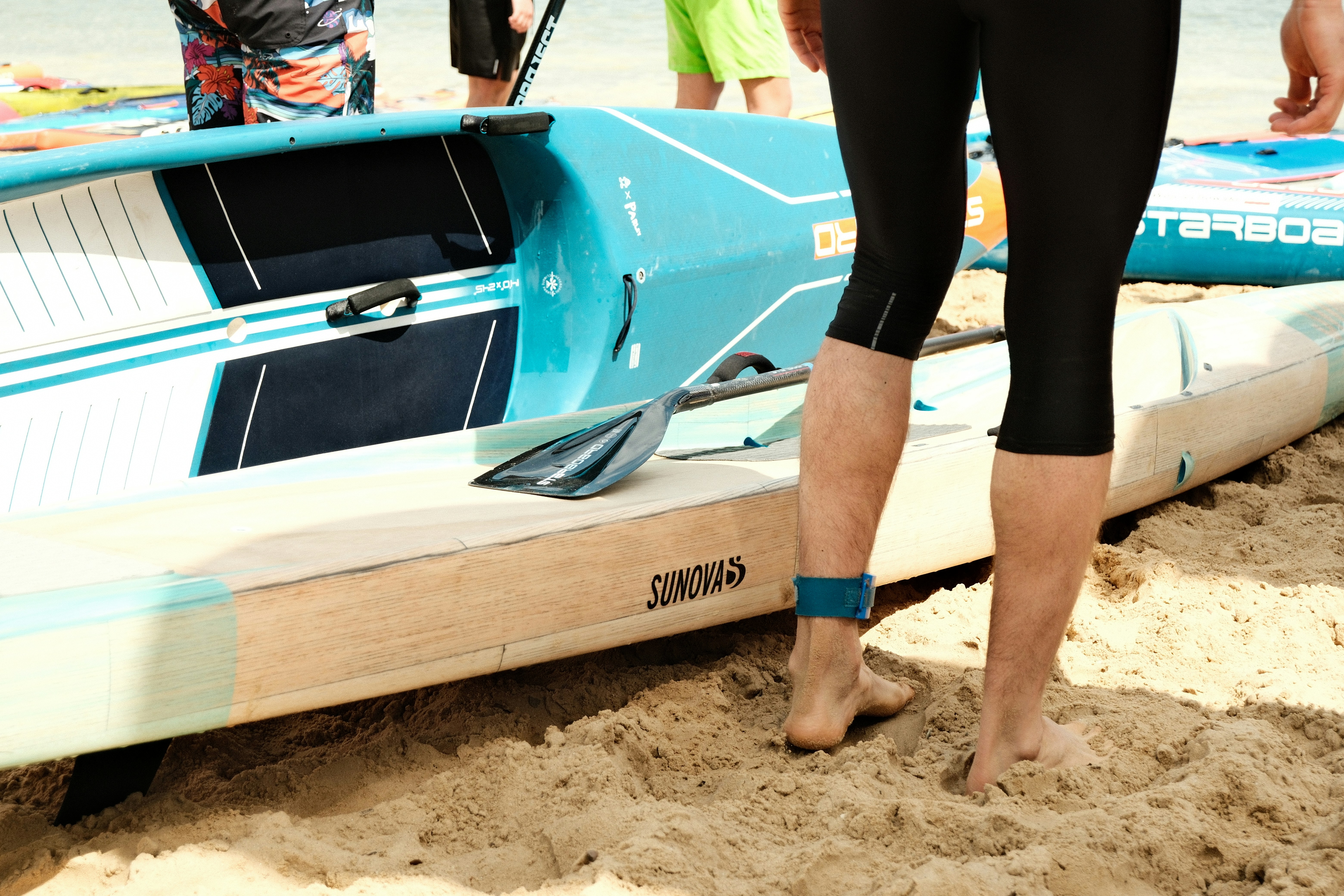 Shoreline Prep: Bare feet and a bright blue SUP on the sand