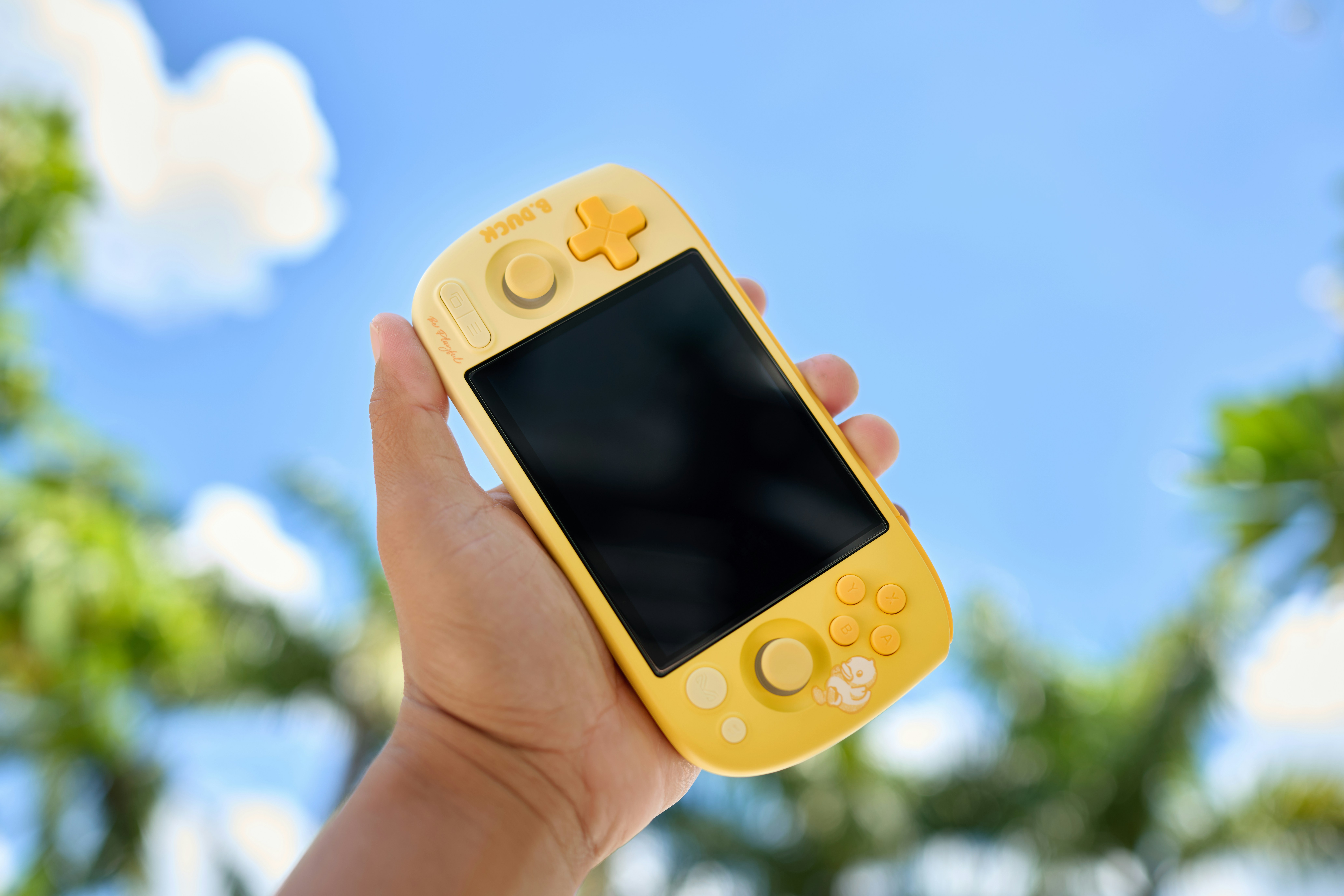 Sunlit handheld vintage-style game console in a tropical breeze