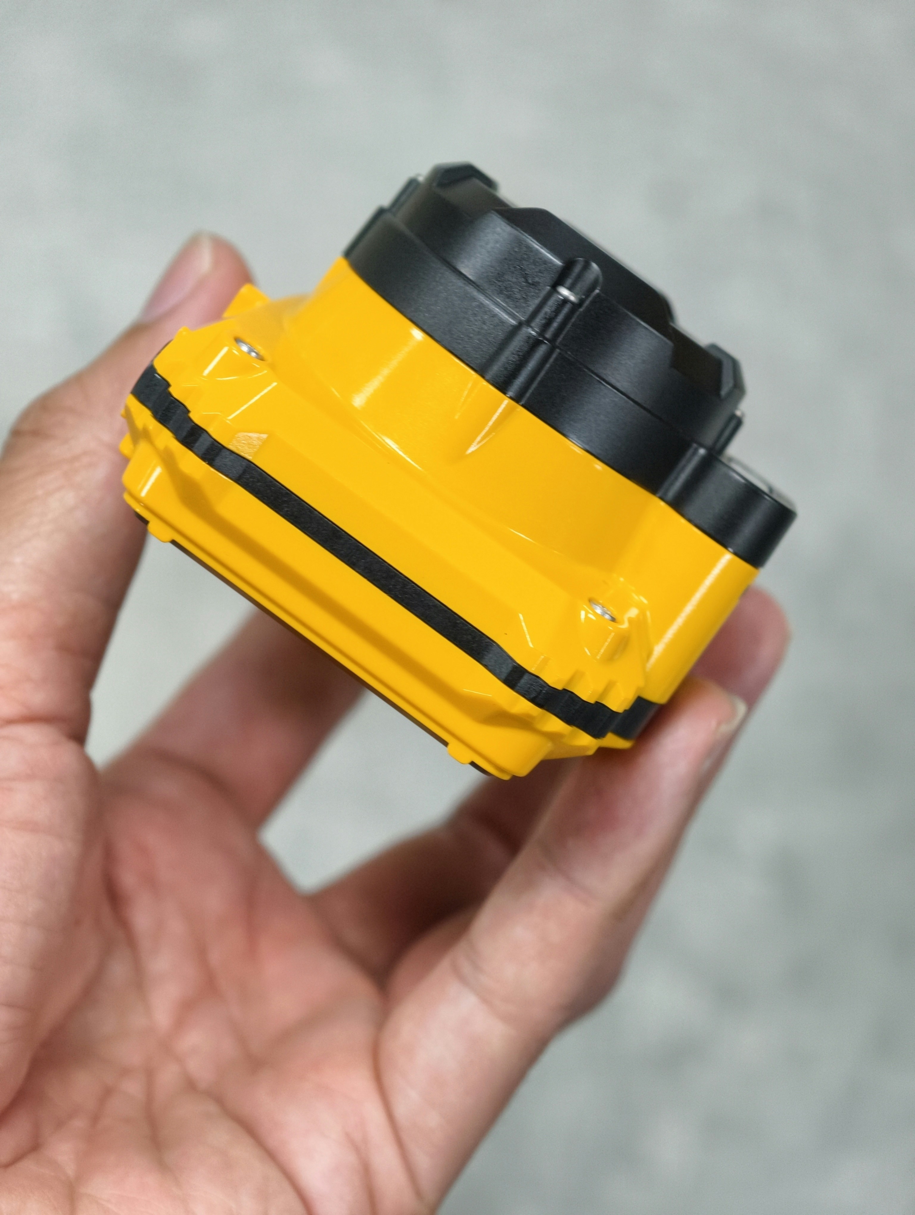 Yellow and Black Compact Object Held Between Fingers