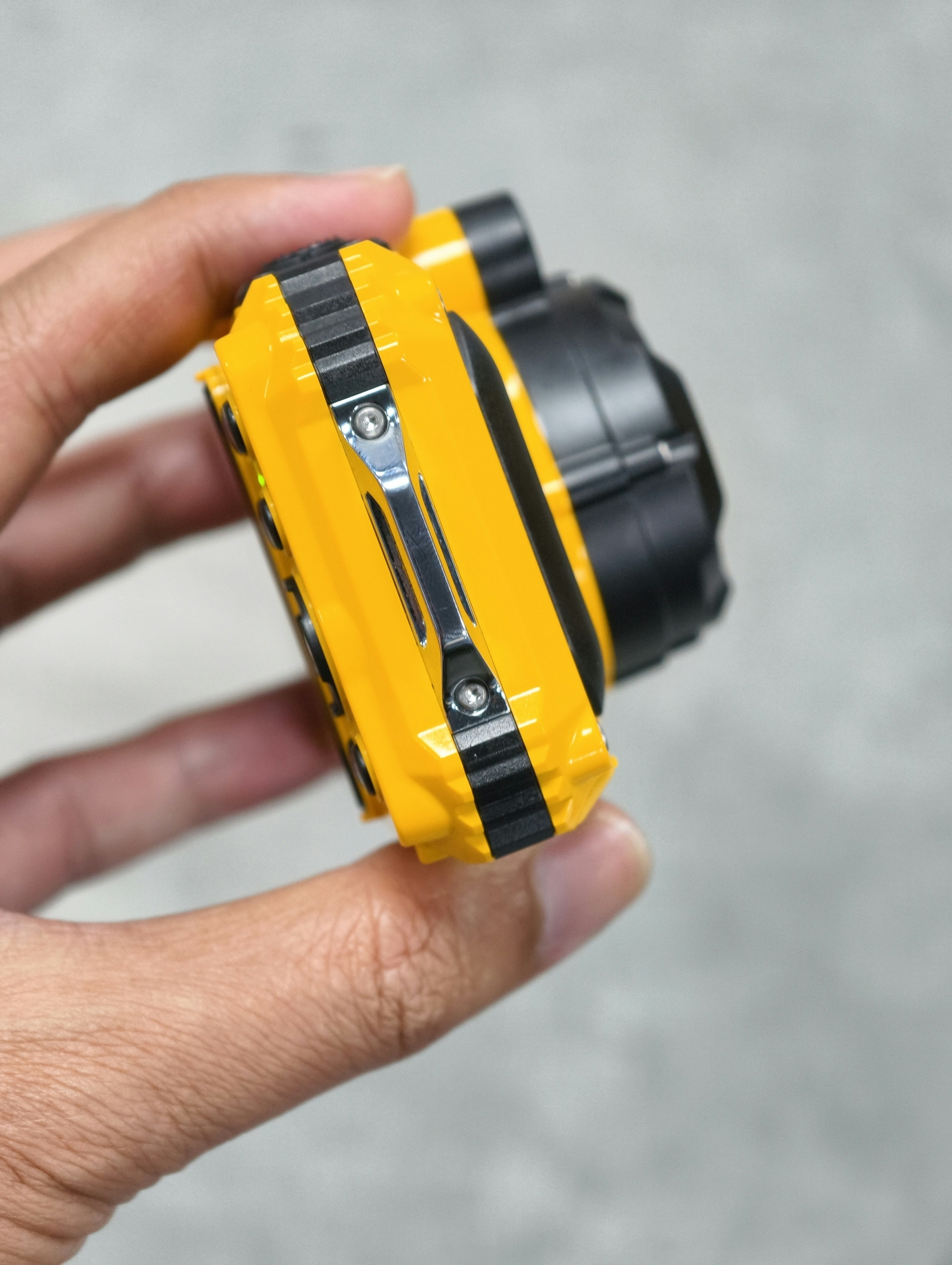 Bright Yellow Gadget in Hand: A Close-Up of a Compact Tool