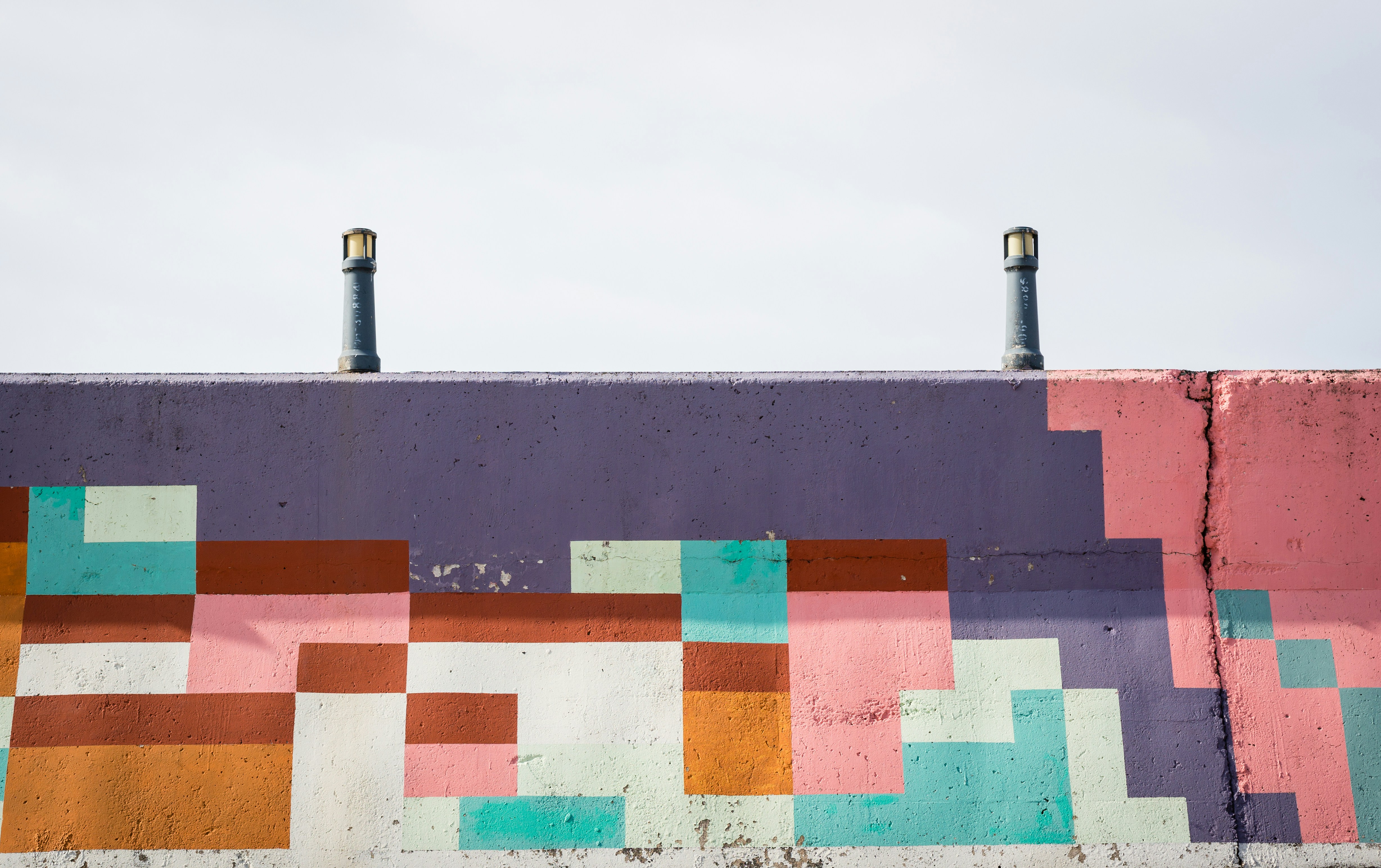 Constellations on a Concrete Wall: A Colorful Mosaic under a Pale Sky