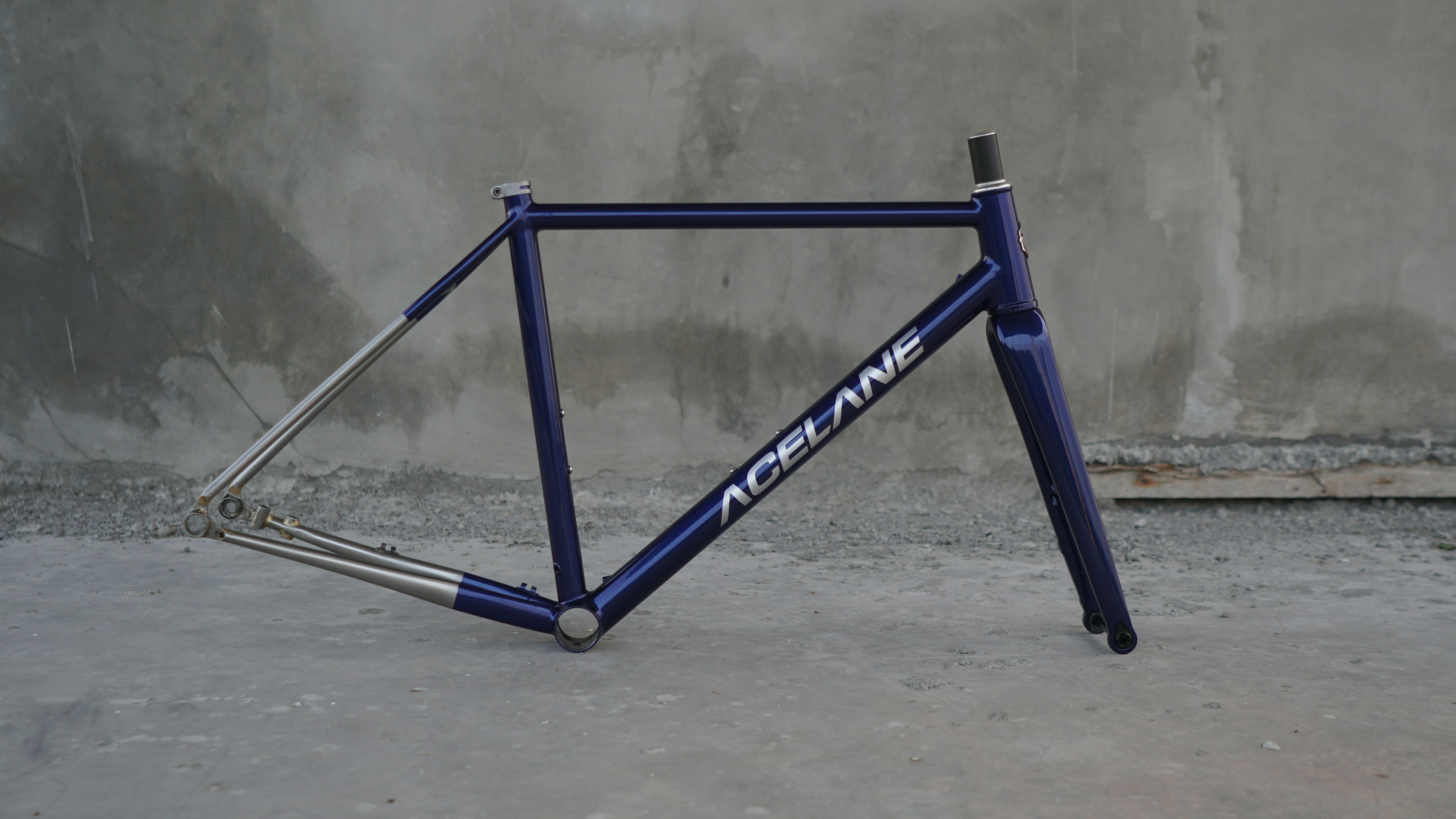 Abandoned blue AGENTD frame resting against a concrete wall