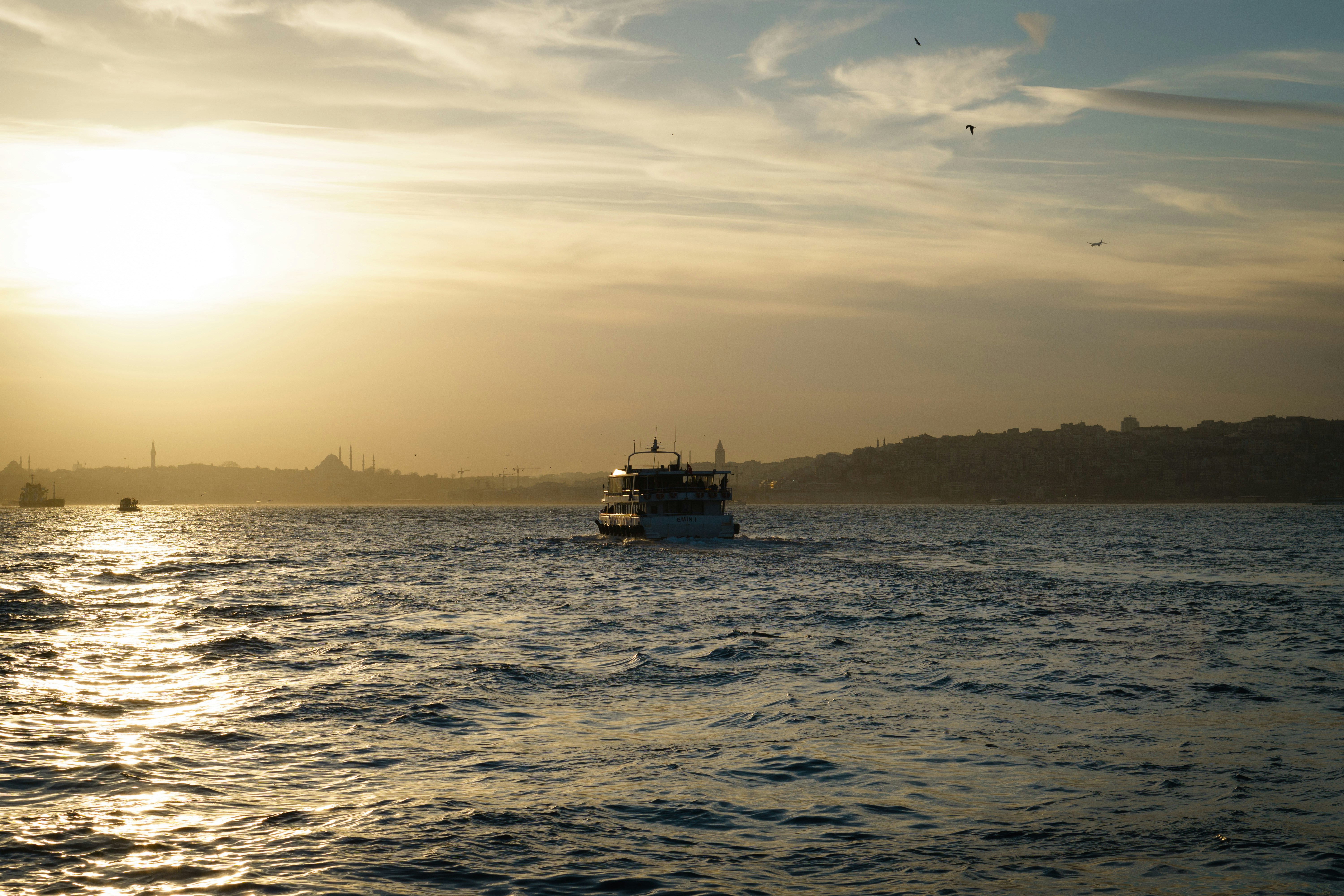Sunlit Vessel on Calm Seas at Dusk