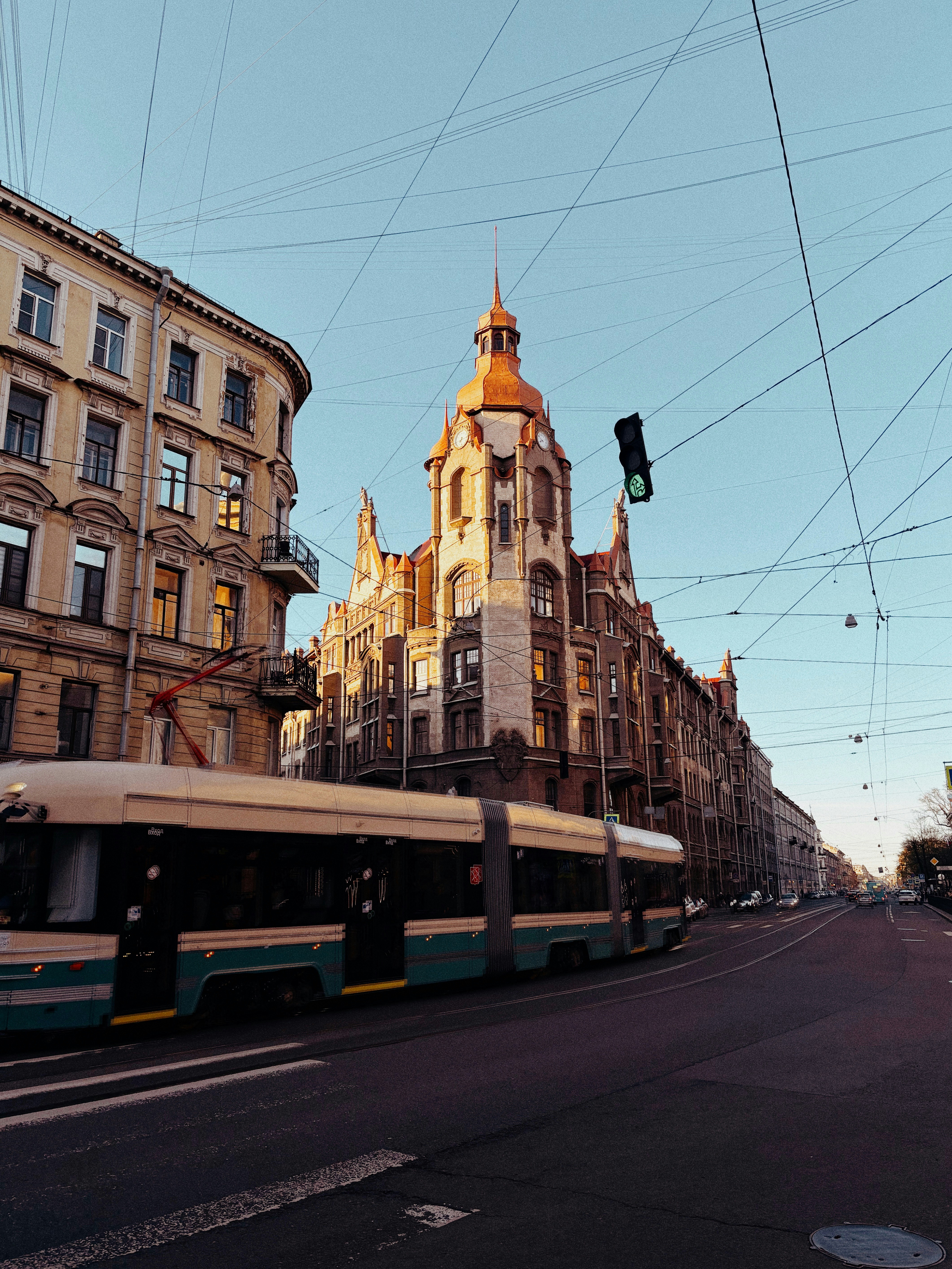 Tram Along a Sunlit Boulevard Under an Interwoven Sky