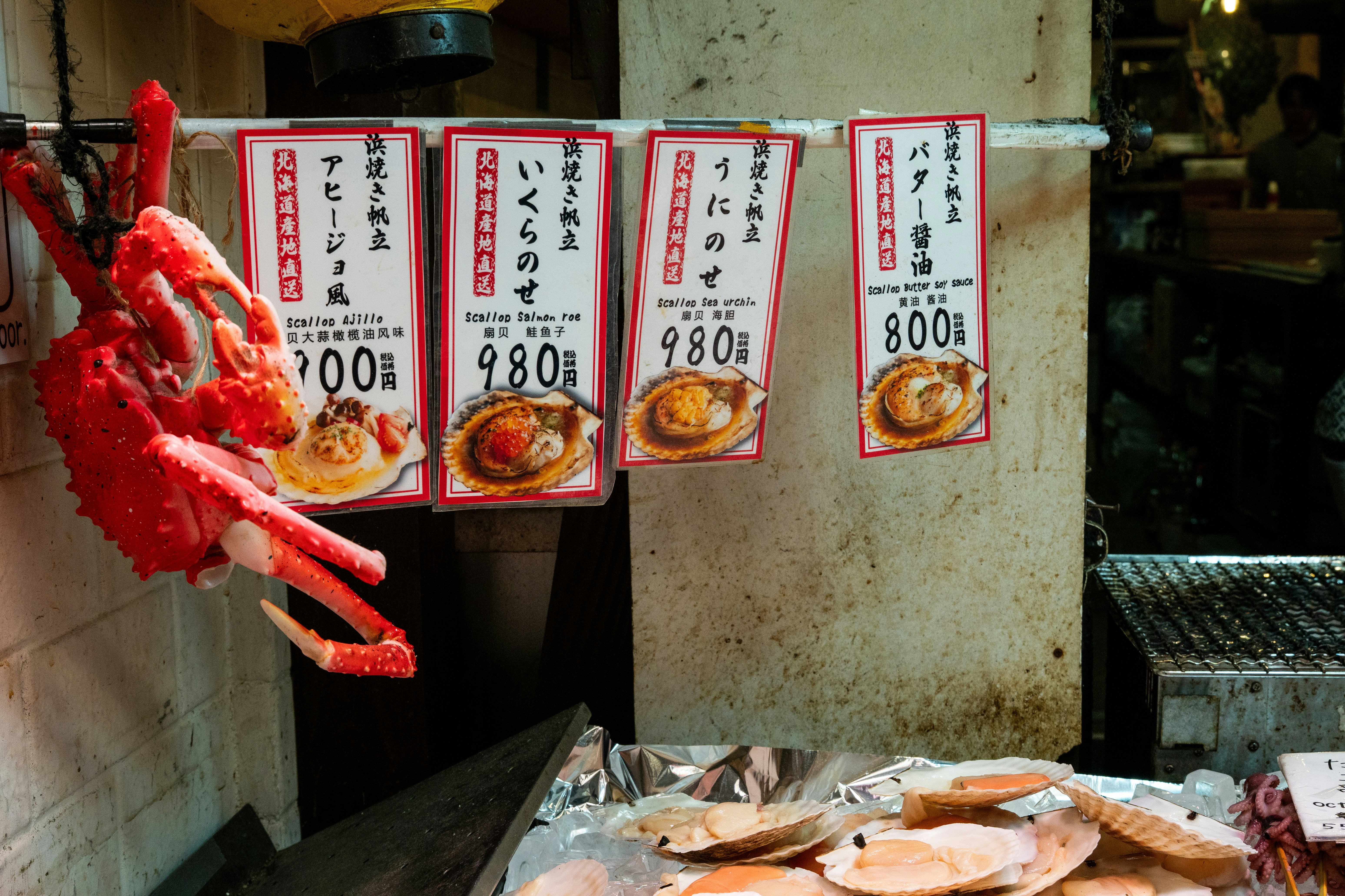Fresh seafood market stall with hanging crab and scallops.