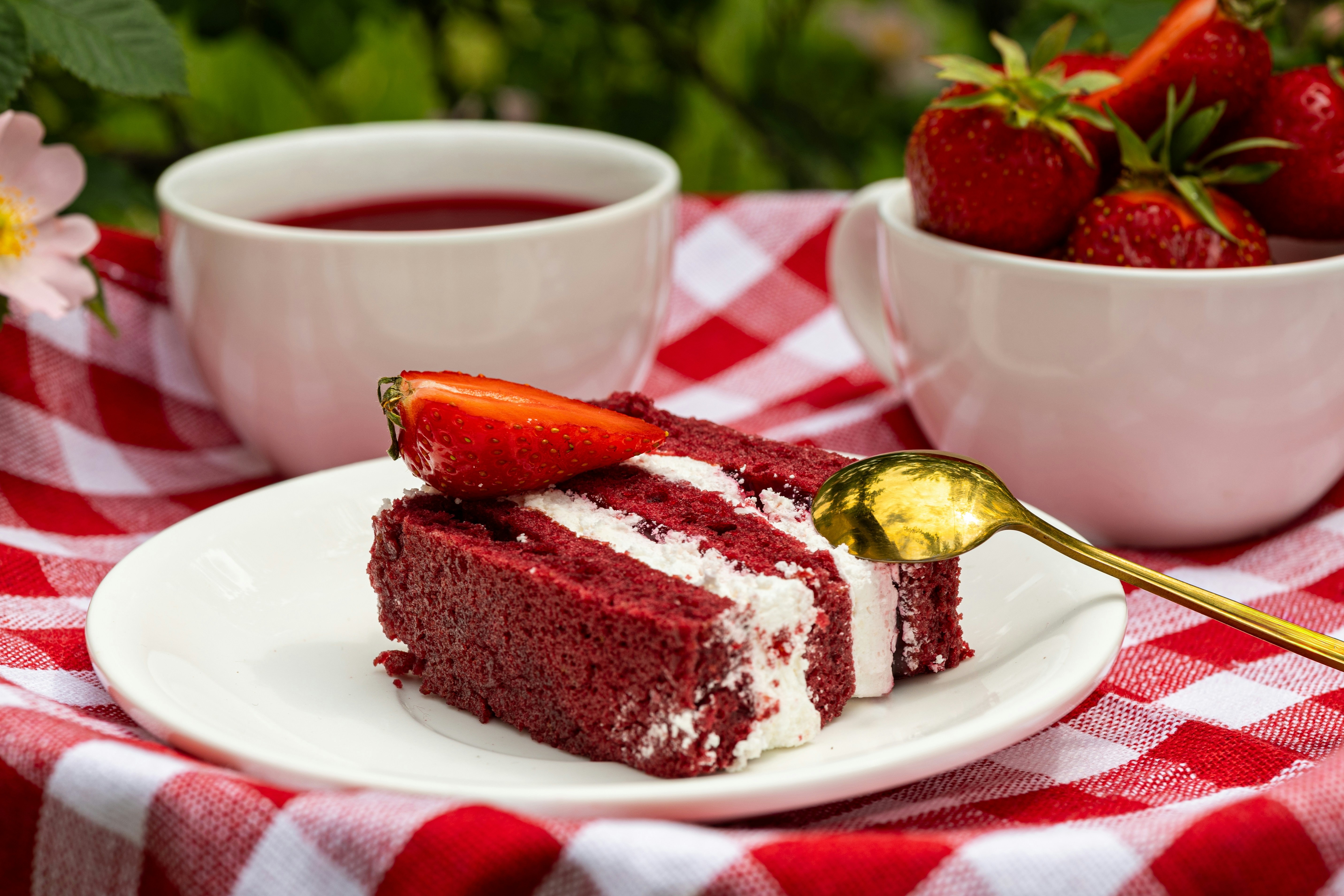 Strawberry-Top Red Velvet Slice at a Picnic Table