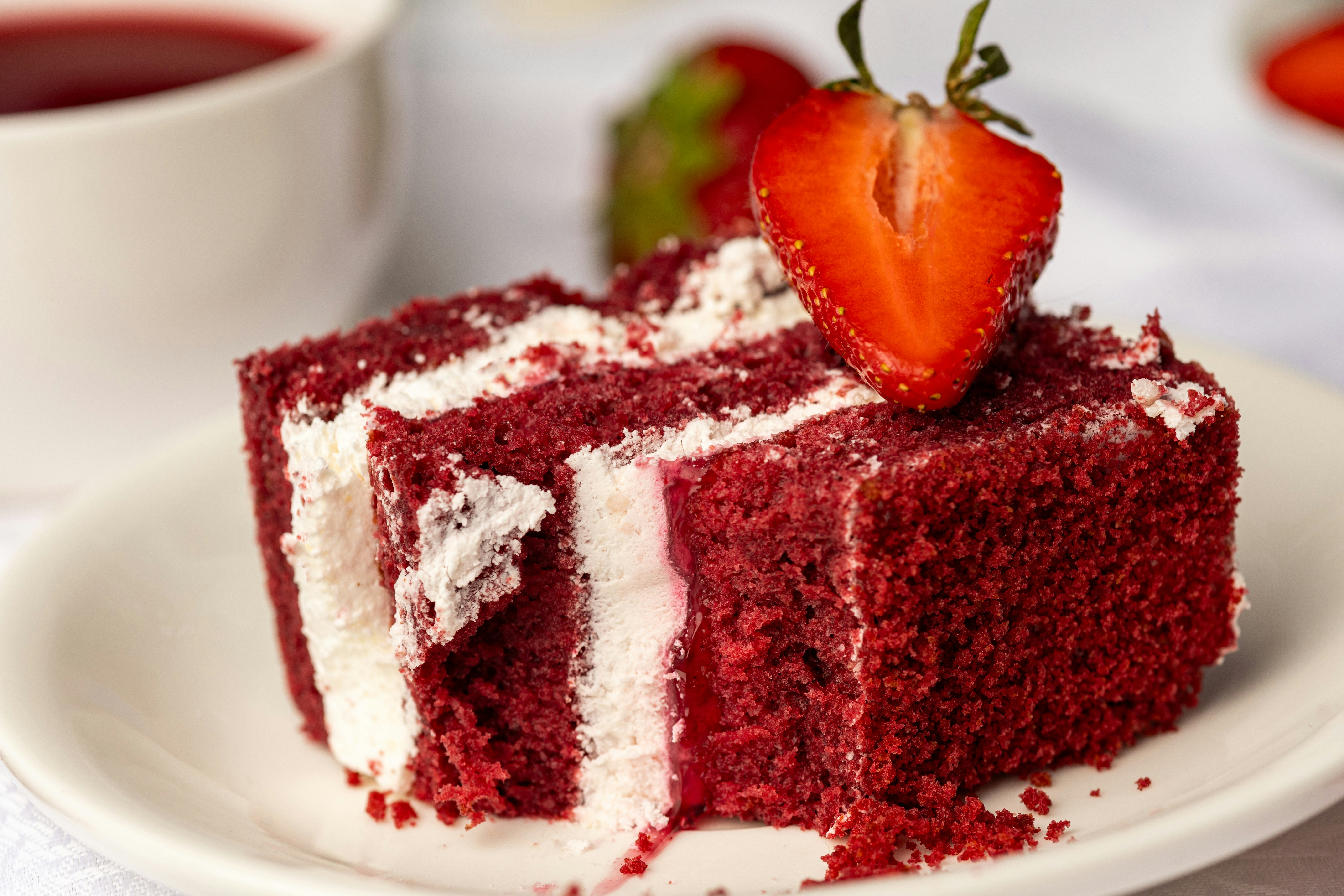 Delicious red velvet cake slice topped with a fresh strawberry.