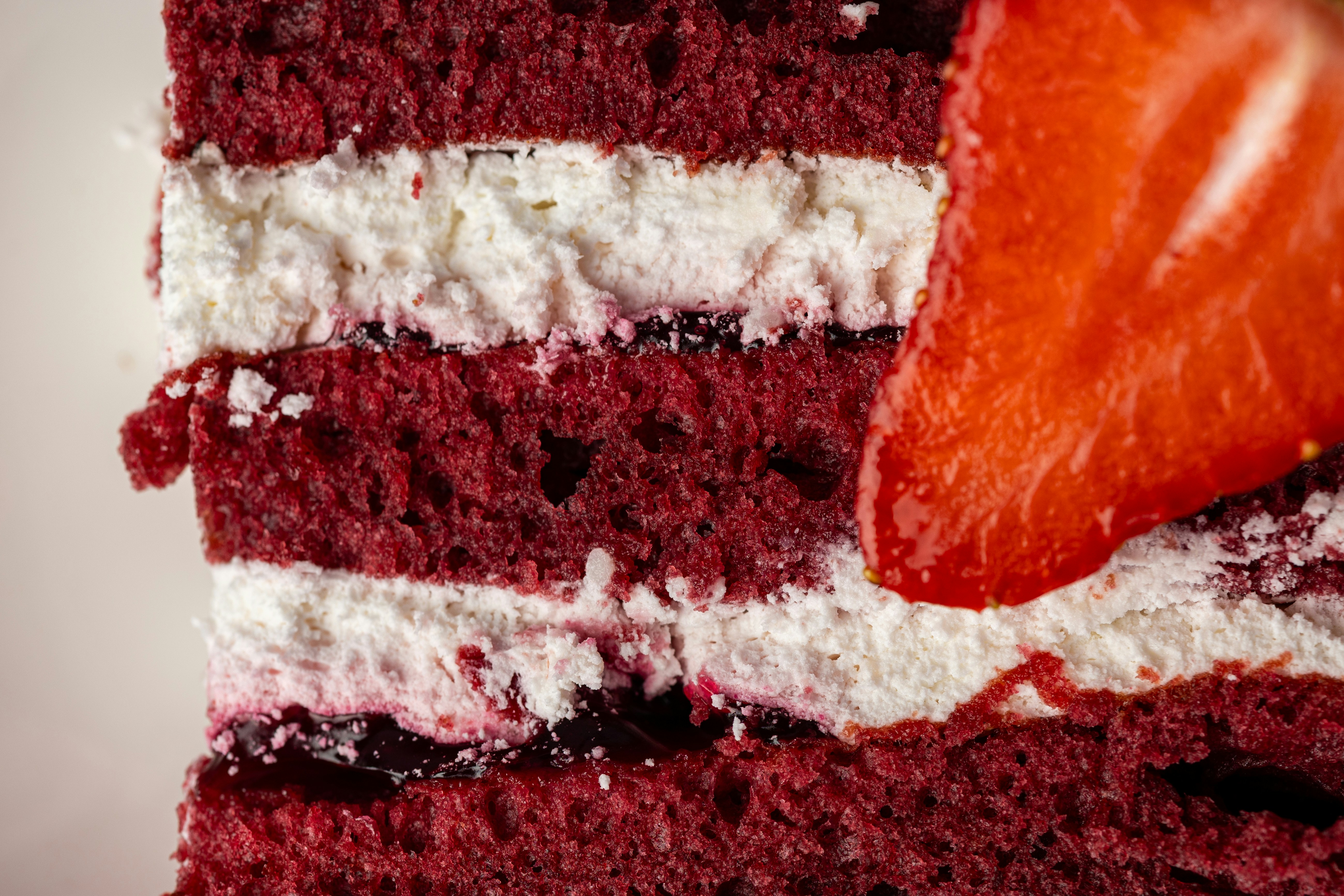Delicious red velvet cake slice topped with fresh strawberry.