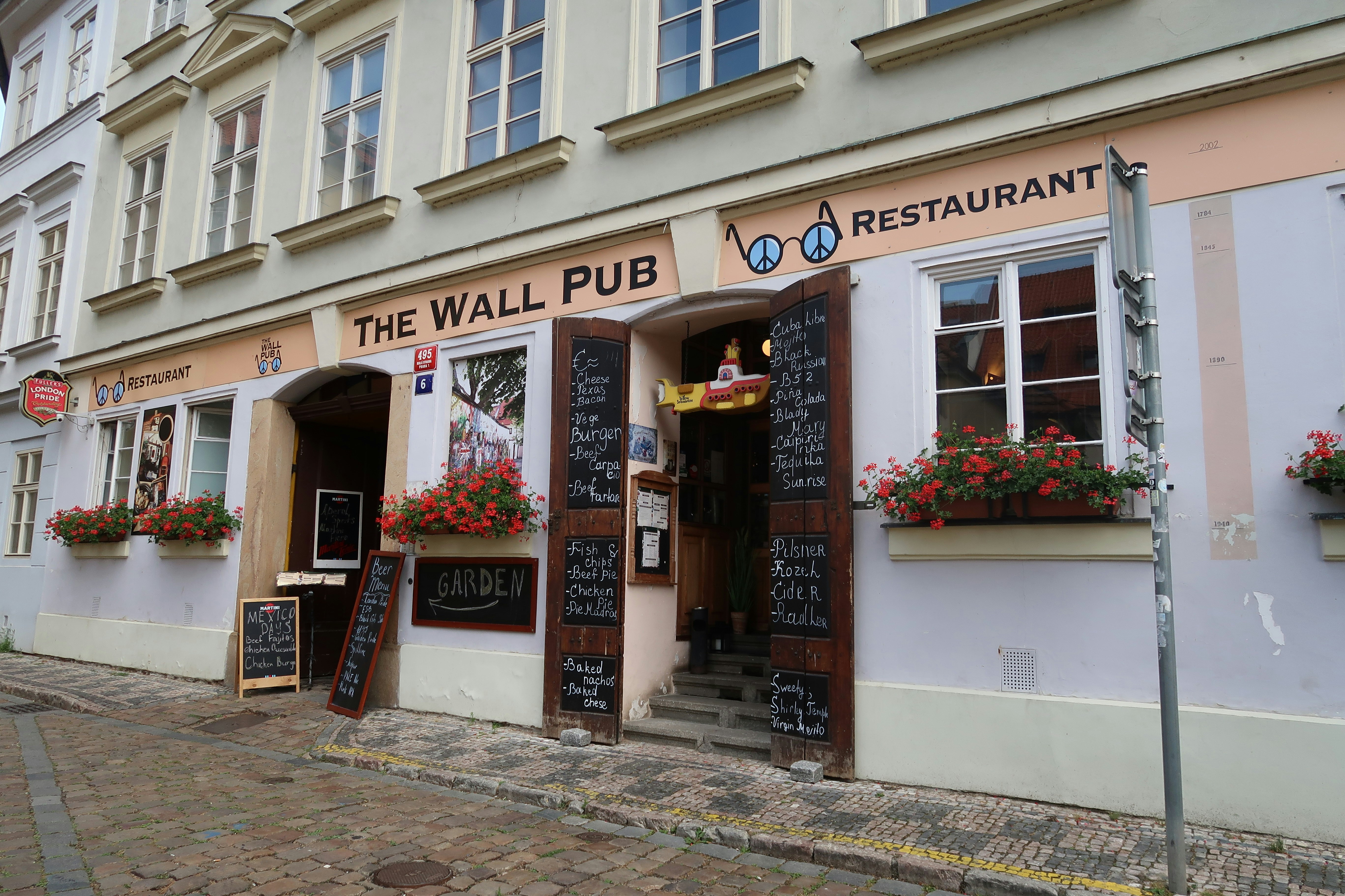 The Wall Pub: A Cobblestone Corridor to a Floral-Filled Entrance